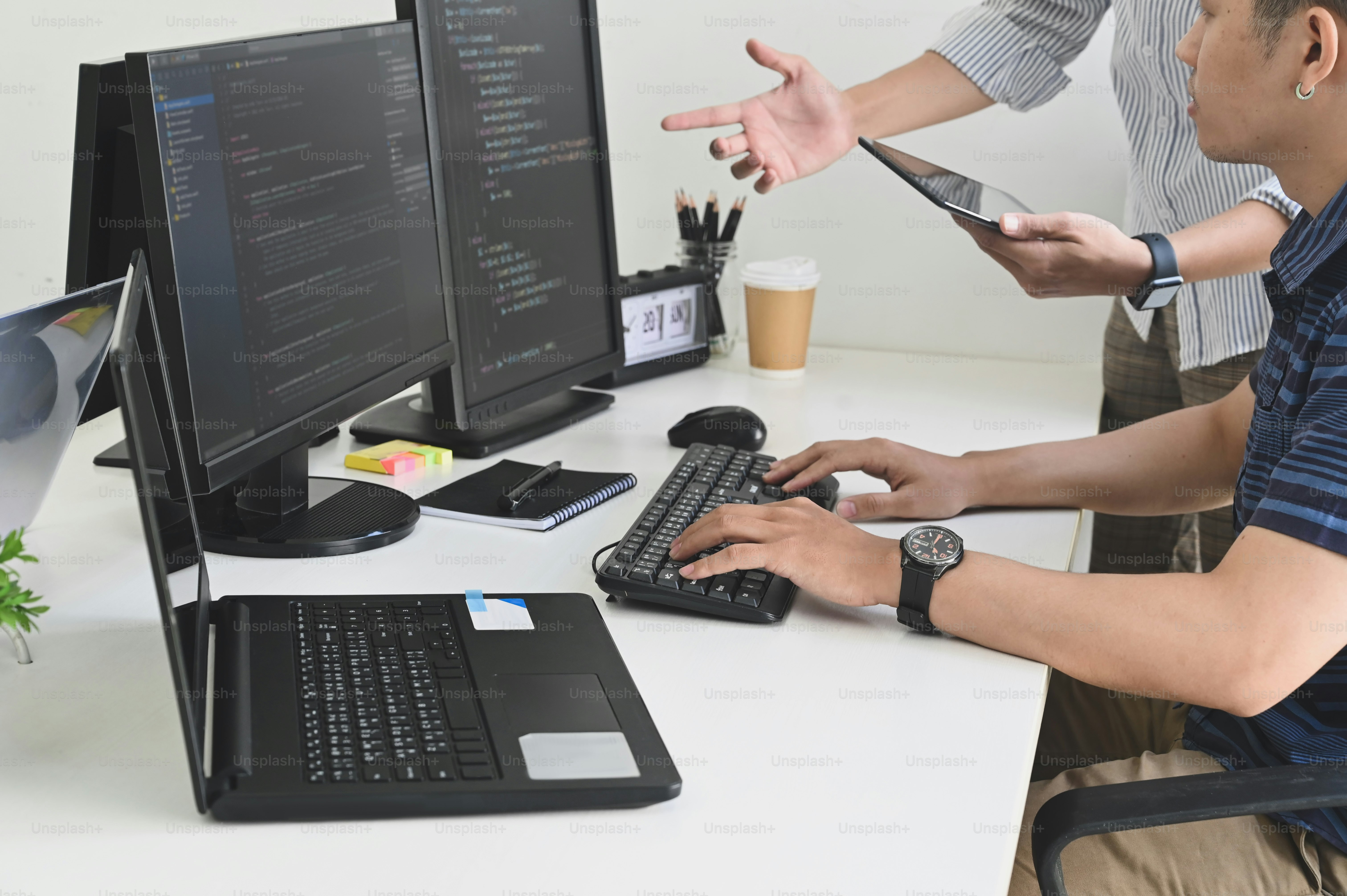 Young programmers working on computer and tablet in modern office ...