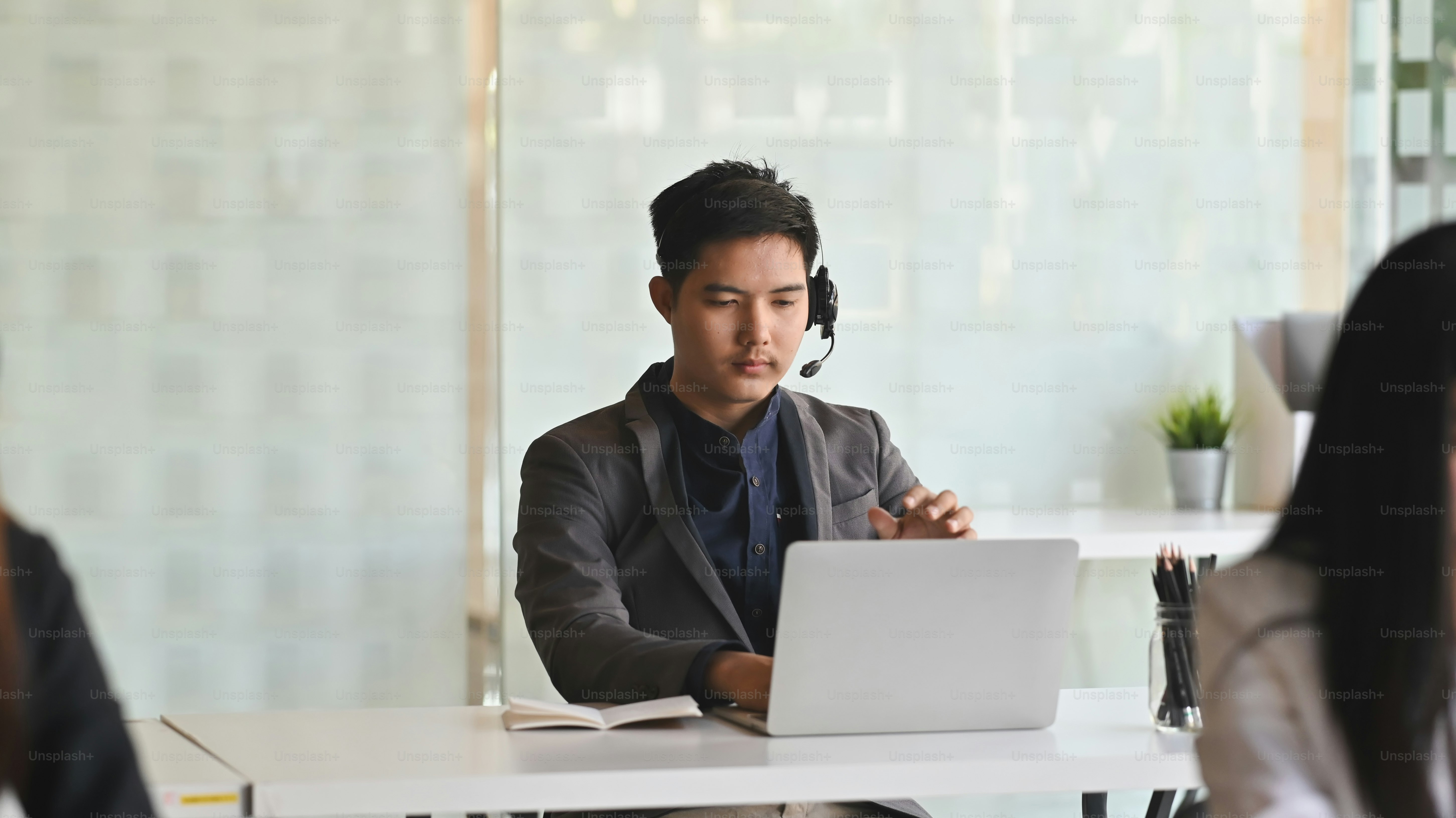 Photo of young smart operator man with headsets while working in a call ...