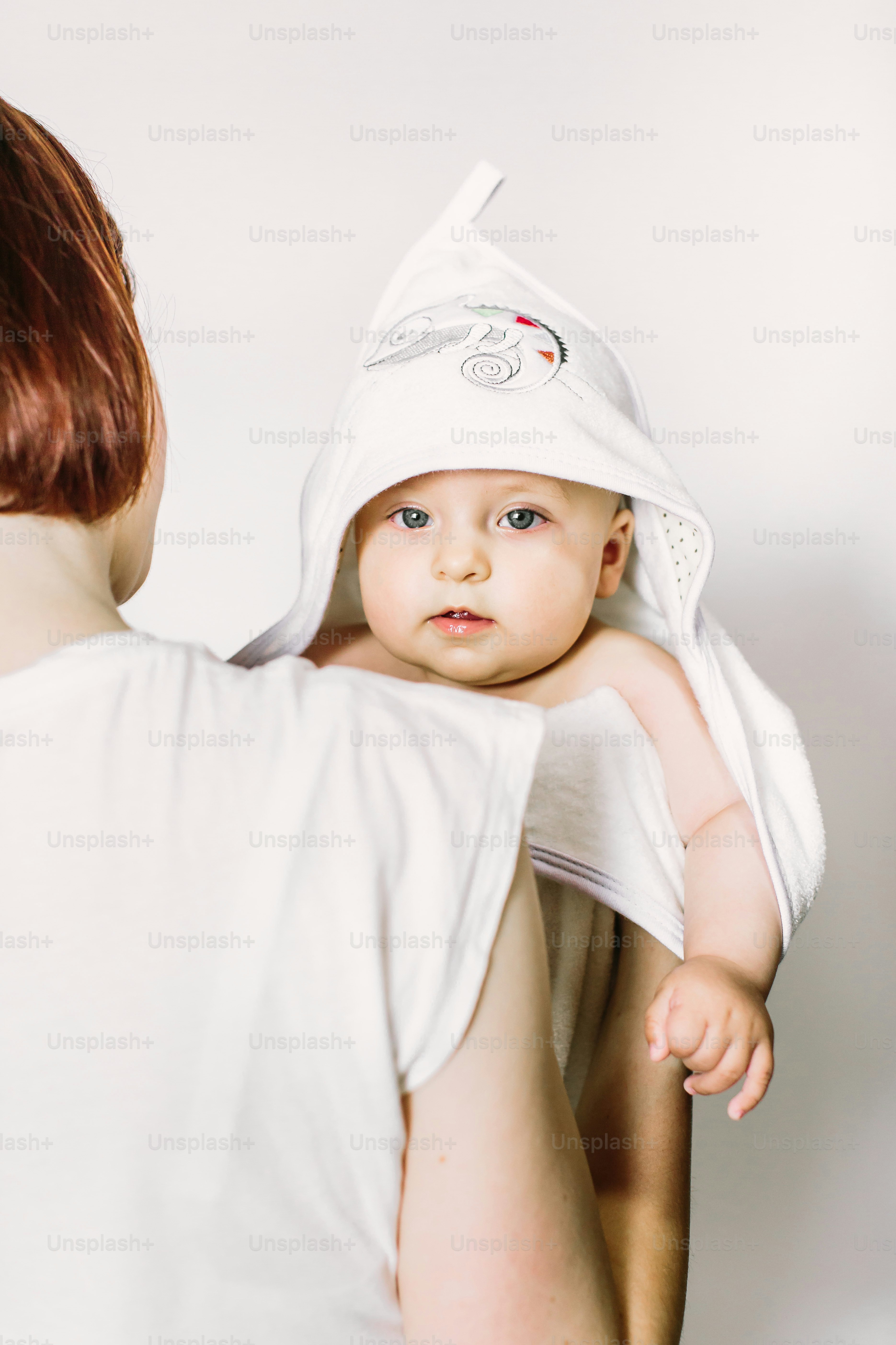 Six month baby wearing towel after bath. Childhood and baby care ...