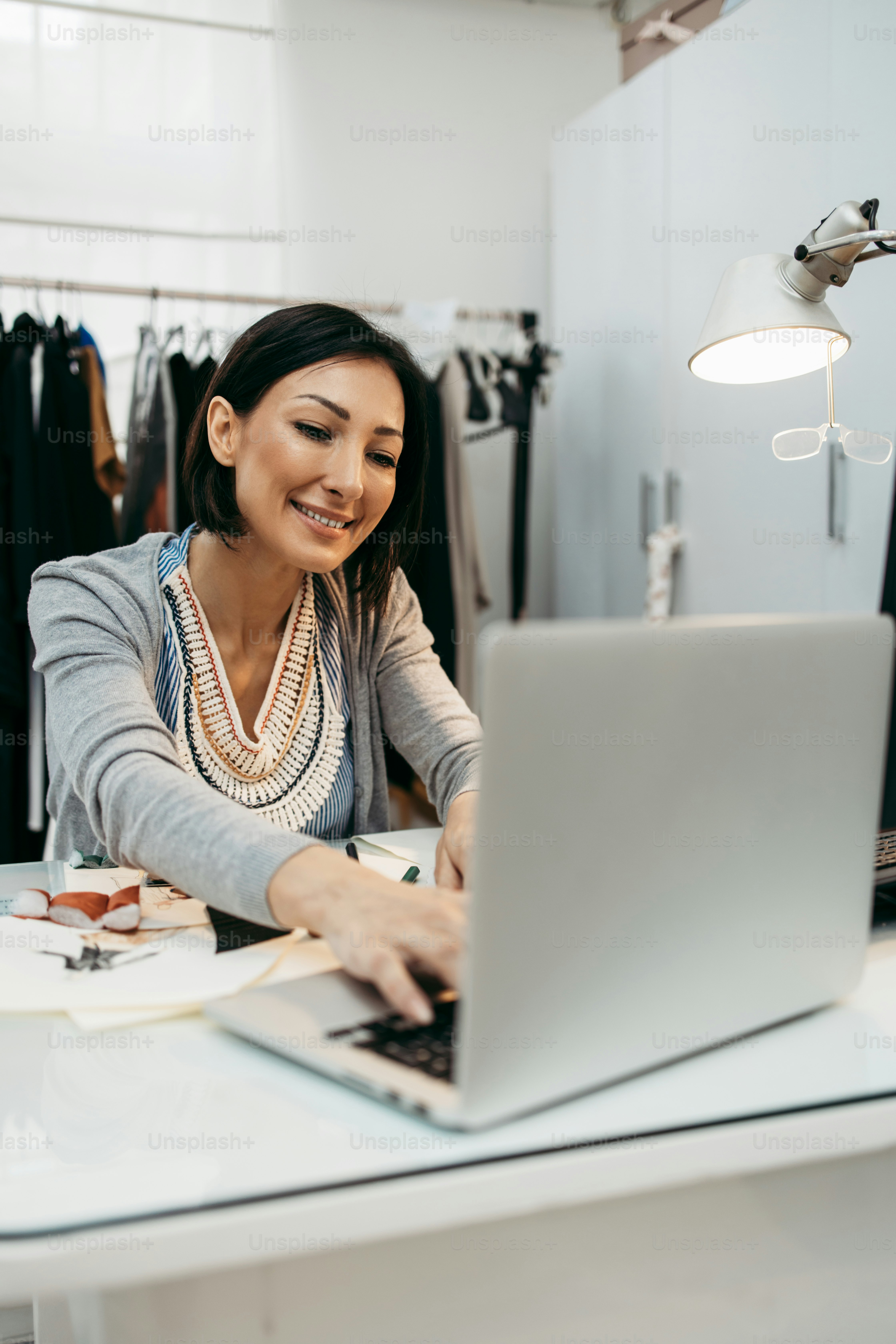 Professional female senior designer working in fashion studio. Creative ...