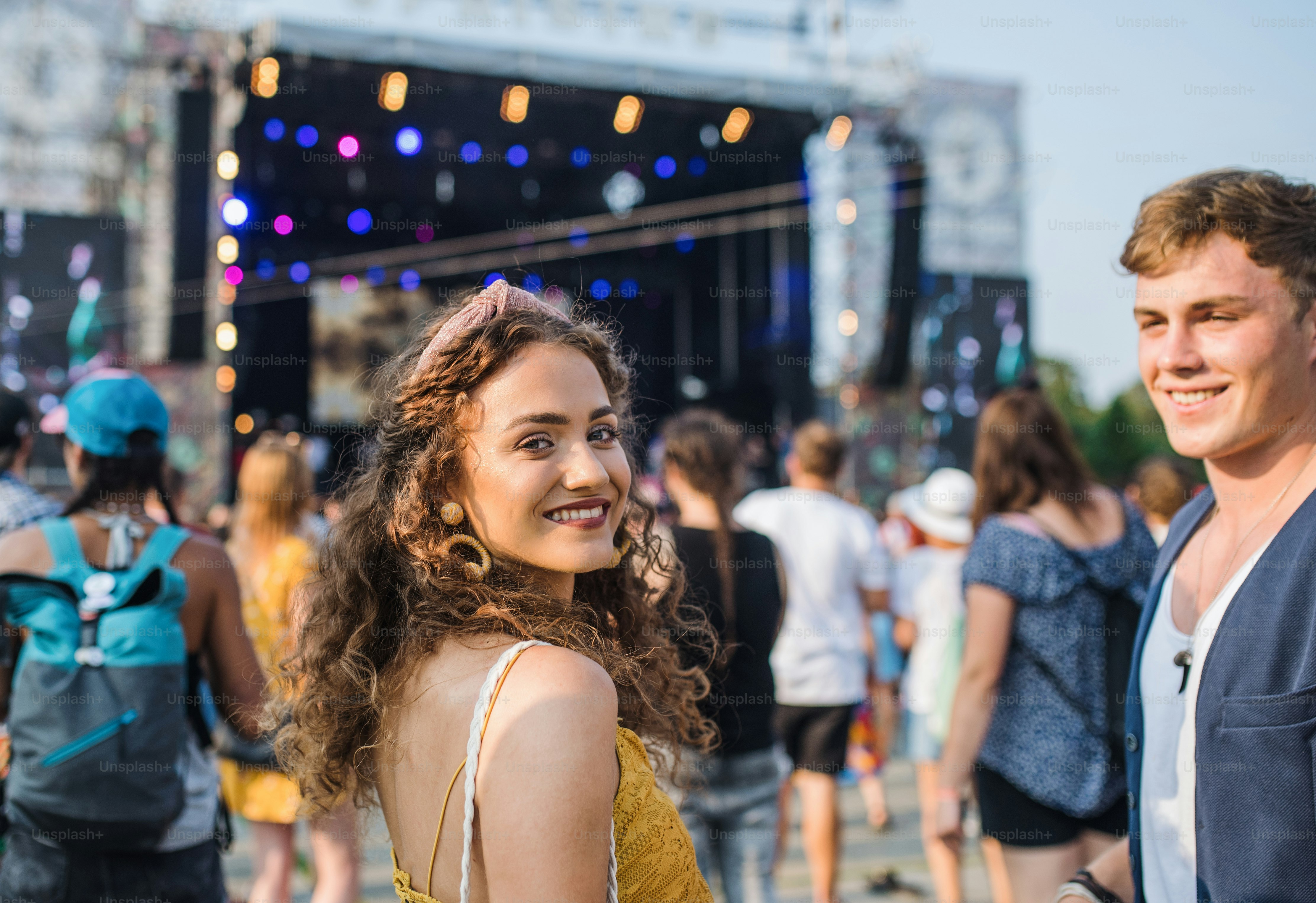 Front view of group of young friends with smartphone at summer festival ...