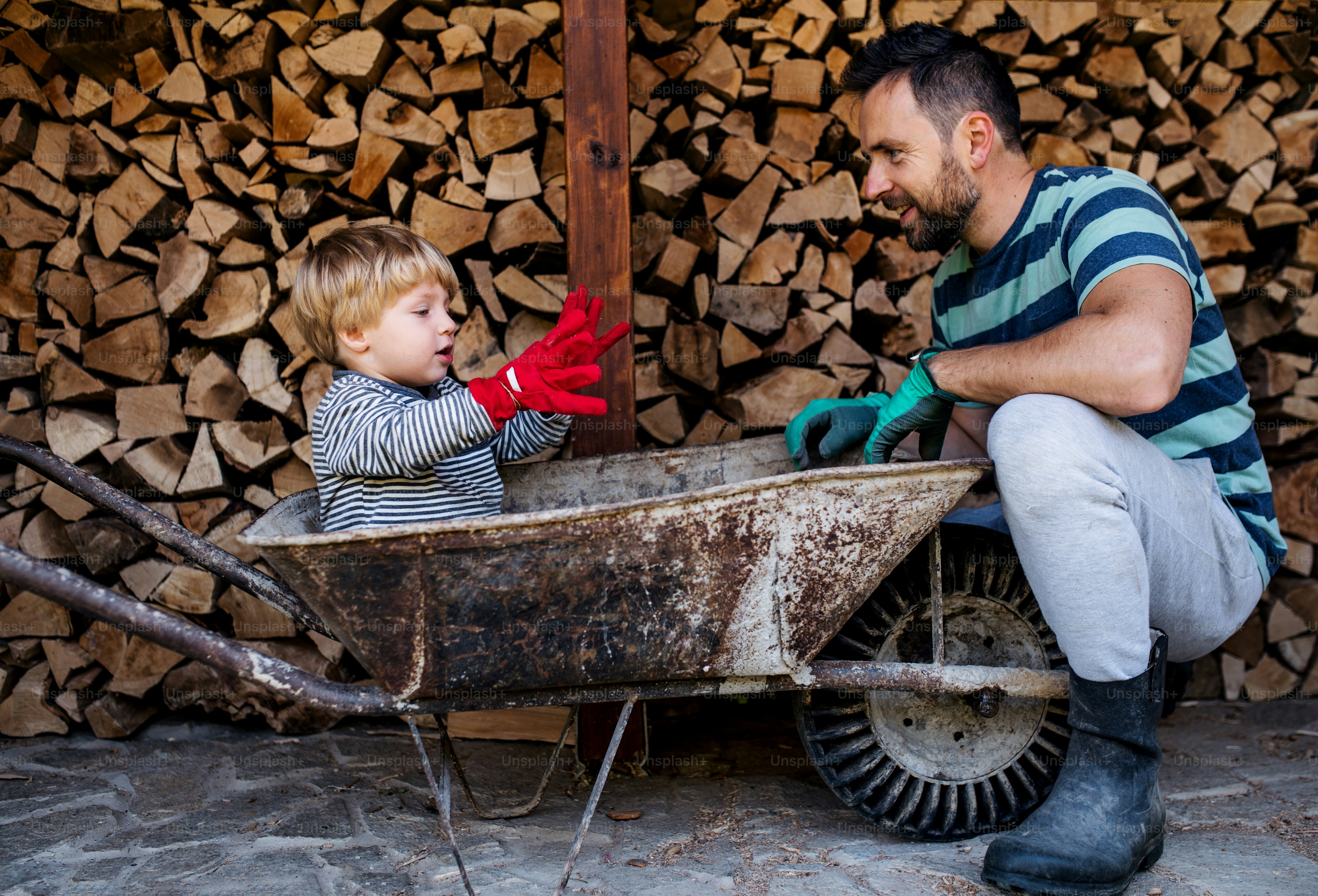 Foto Un padre y un niño pequeño con una carretilla al aire libre en ...