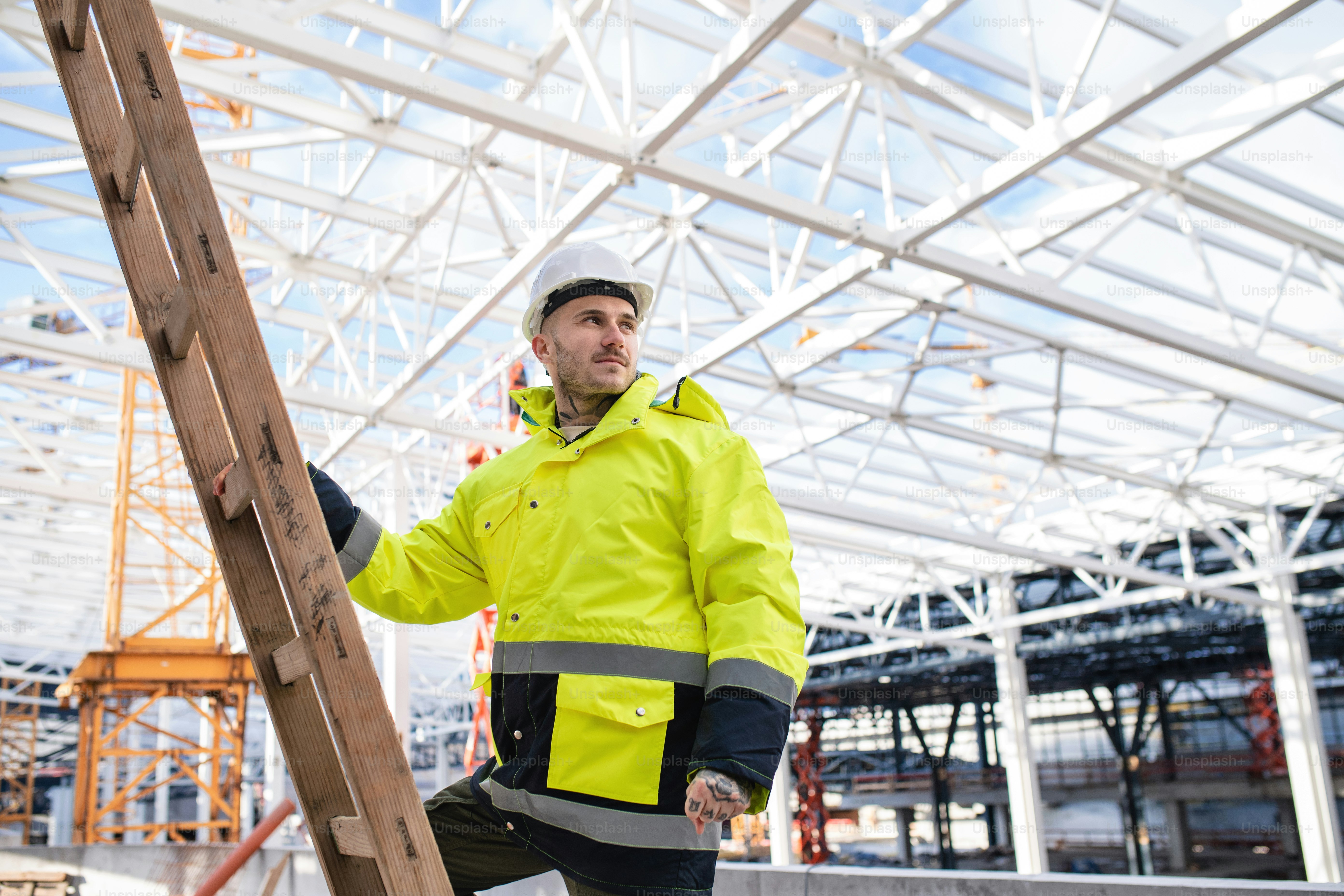 Foto Un joven trabajador al aire libre en un sitio de construcción, trabajando. – Eslovaquia ...