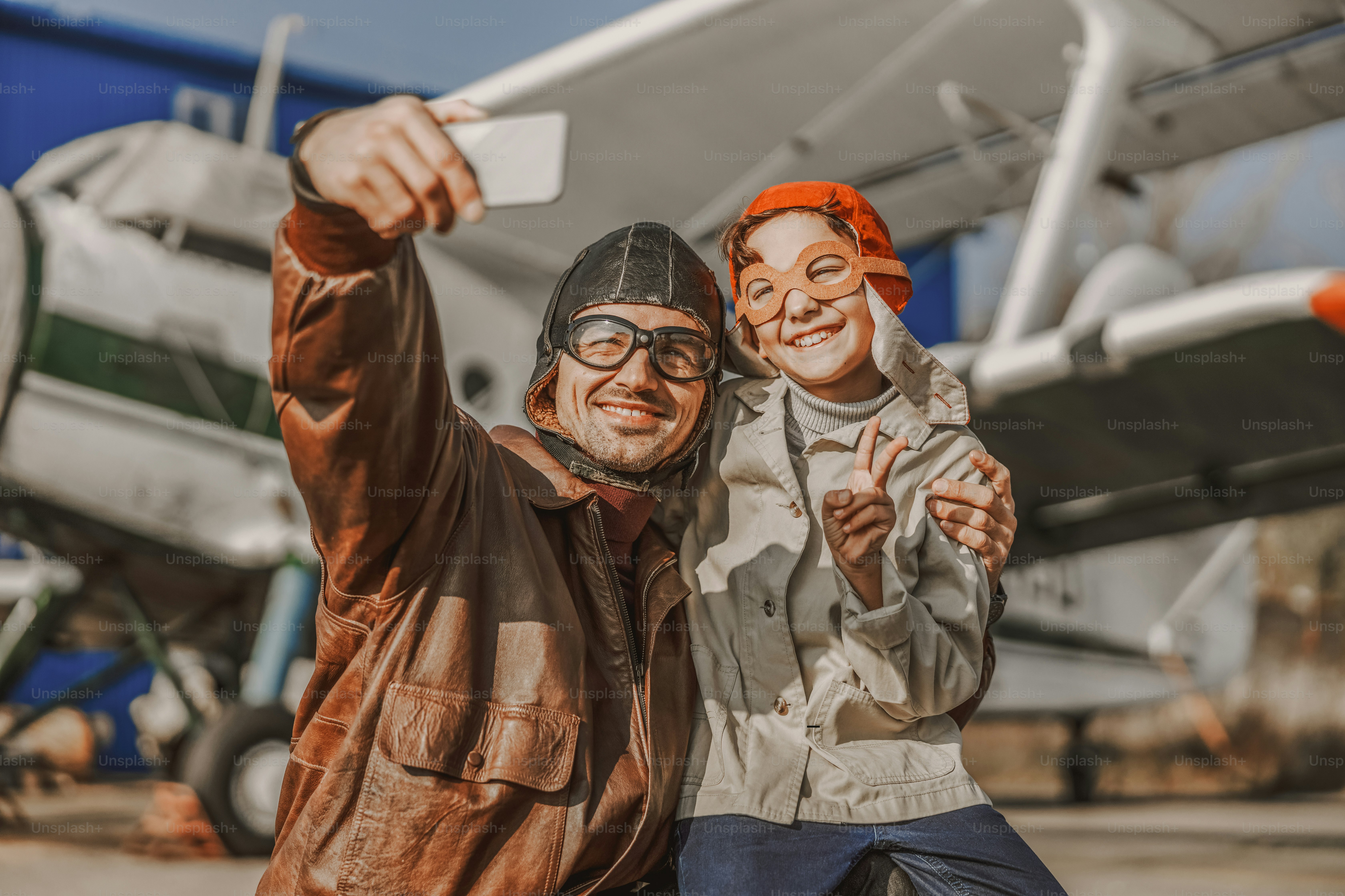 Happy male in aviator glasses using smartphone and taking photo with ...
