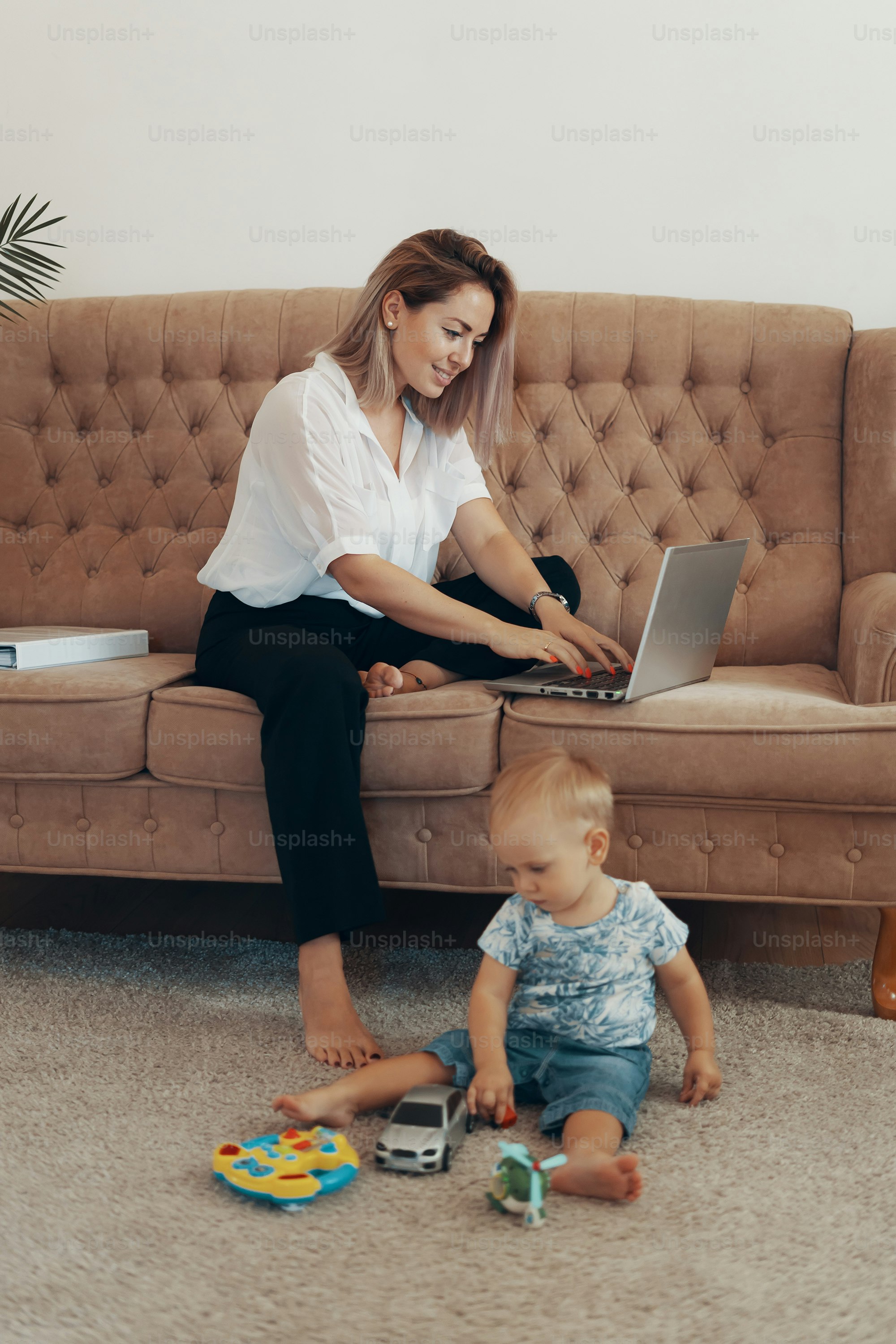 Beautiful business woman working at home. Multi-tasking, freelance and motherhood concept ...