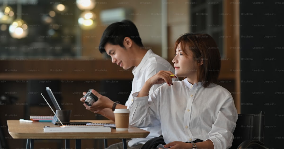 고급 카페 위에 있는 현대적인 나무 테이블에 함께 앉아 컴퓨터 태블릿과 노트북으로 작업하는 웹사이트 관리자 팀의 사진 사무실