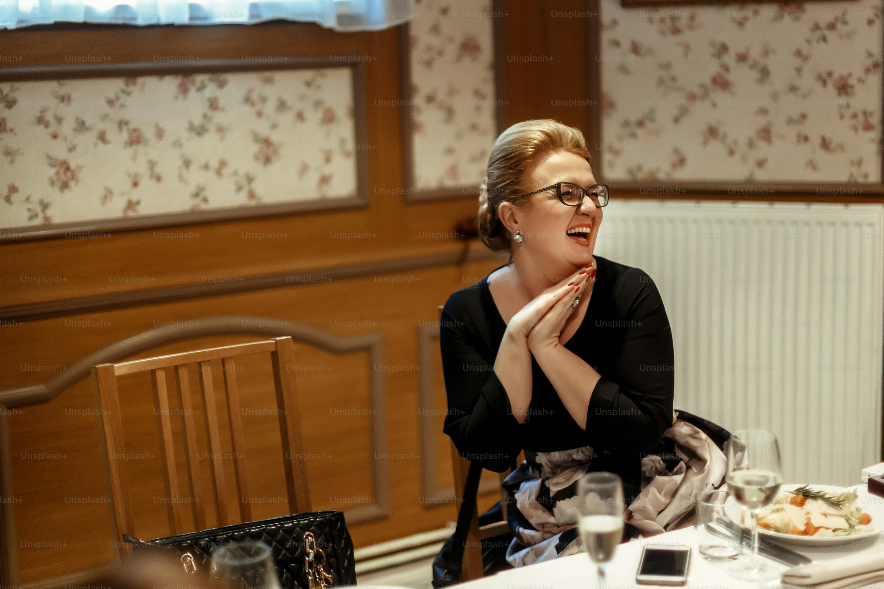 Happy stylish woman in glasses laughing at celebration in restaurant ...