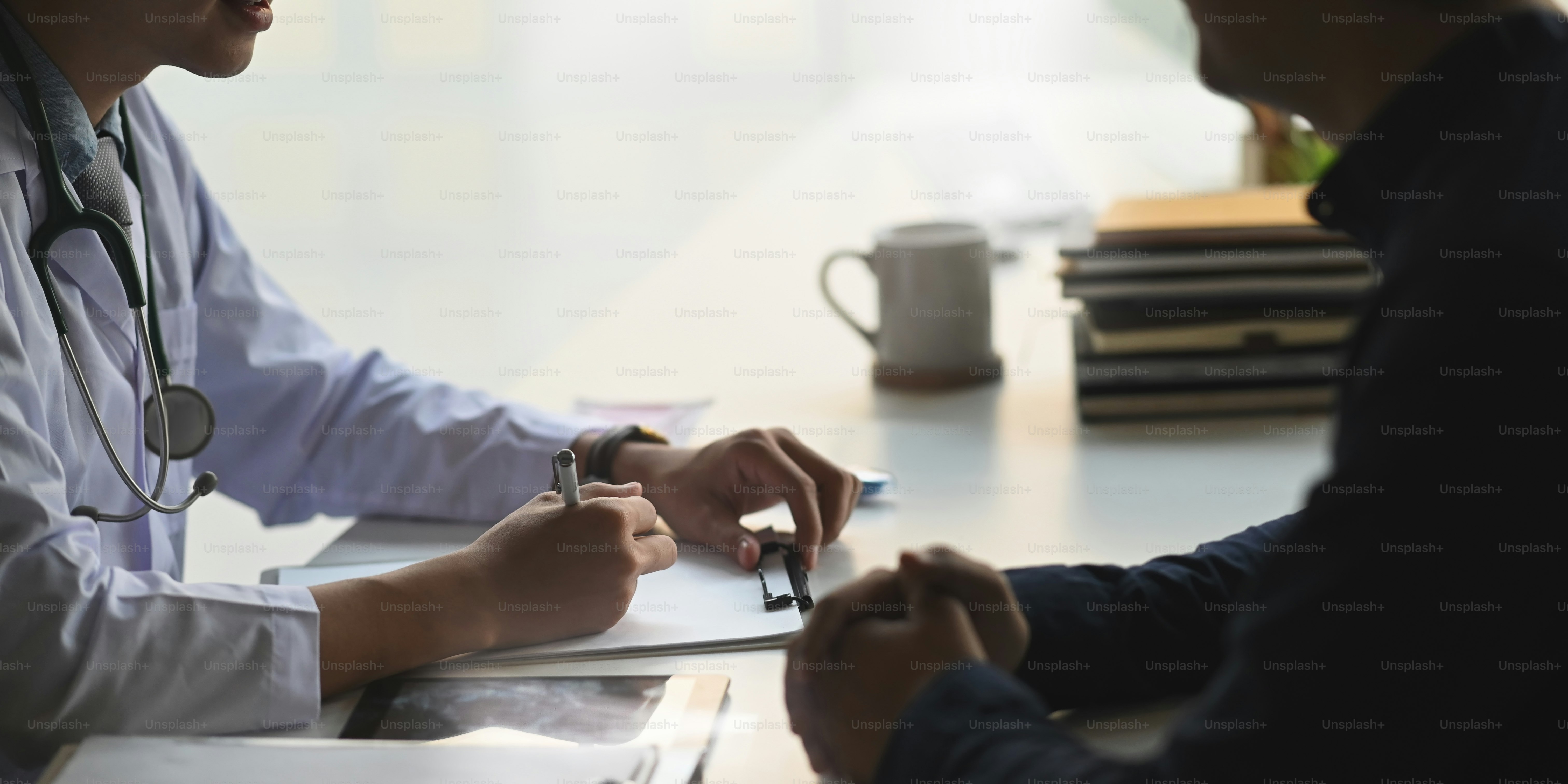 Cropped image of Young smart doctor diagnosing and giving advice to his ...