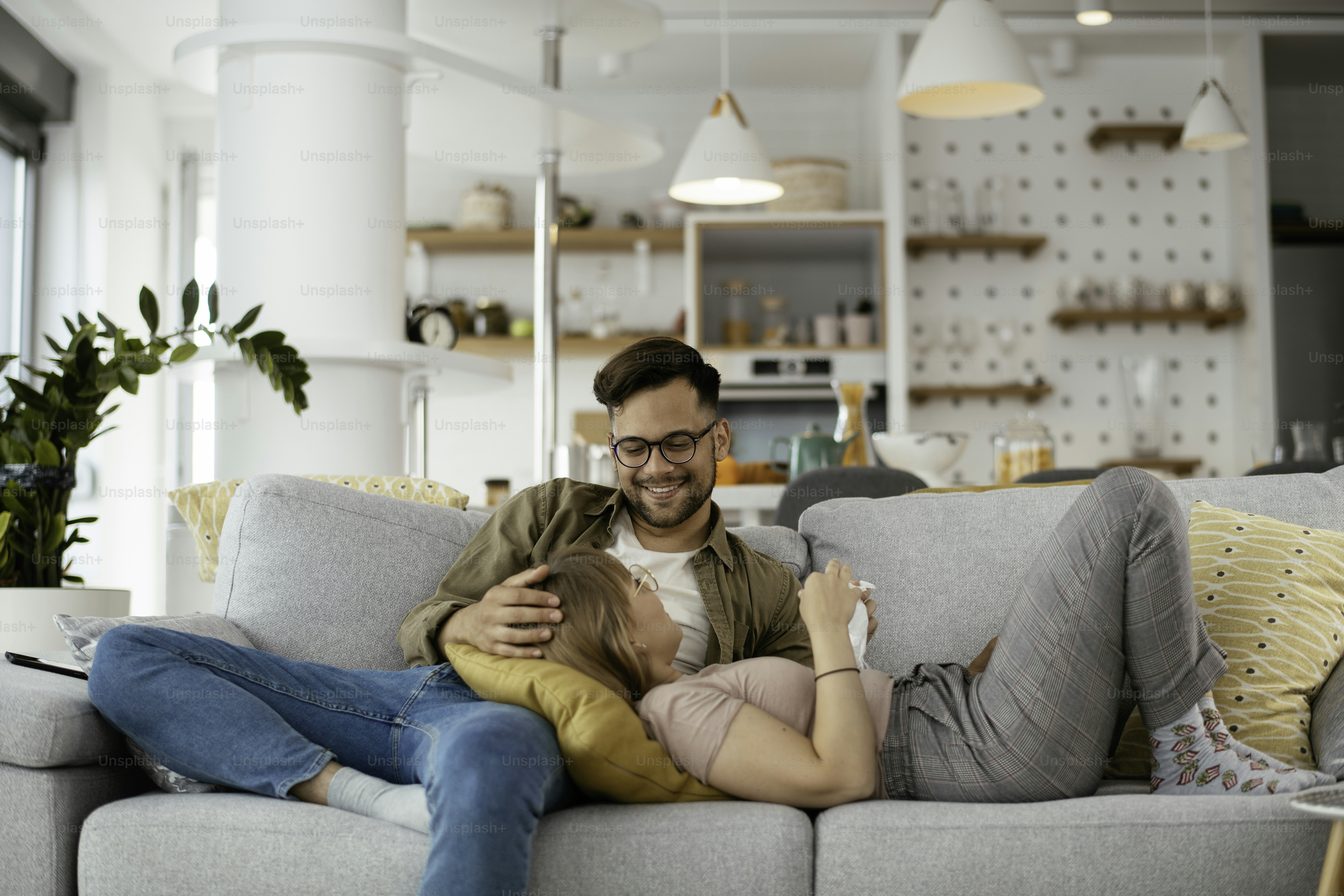 Jeune couple d'amoureux dans le canapé. Heureux couple se détendre dans ...