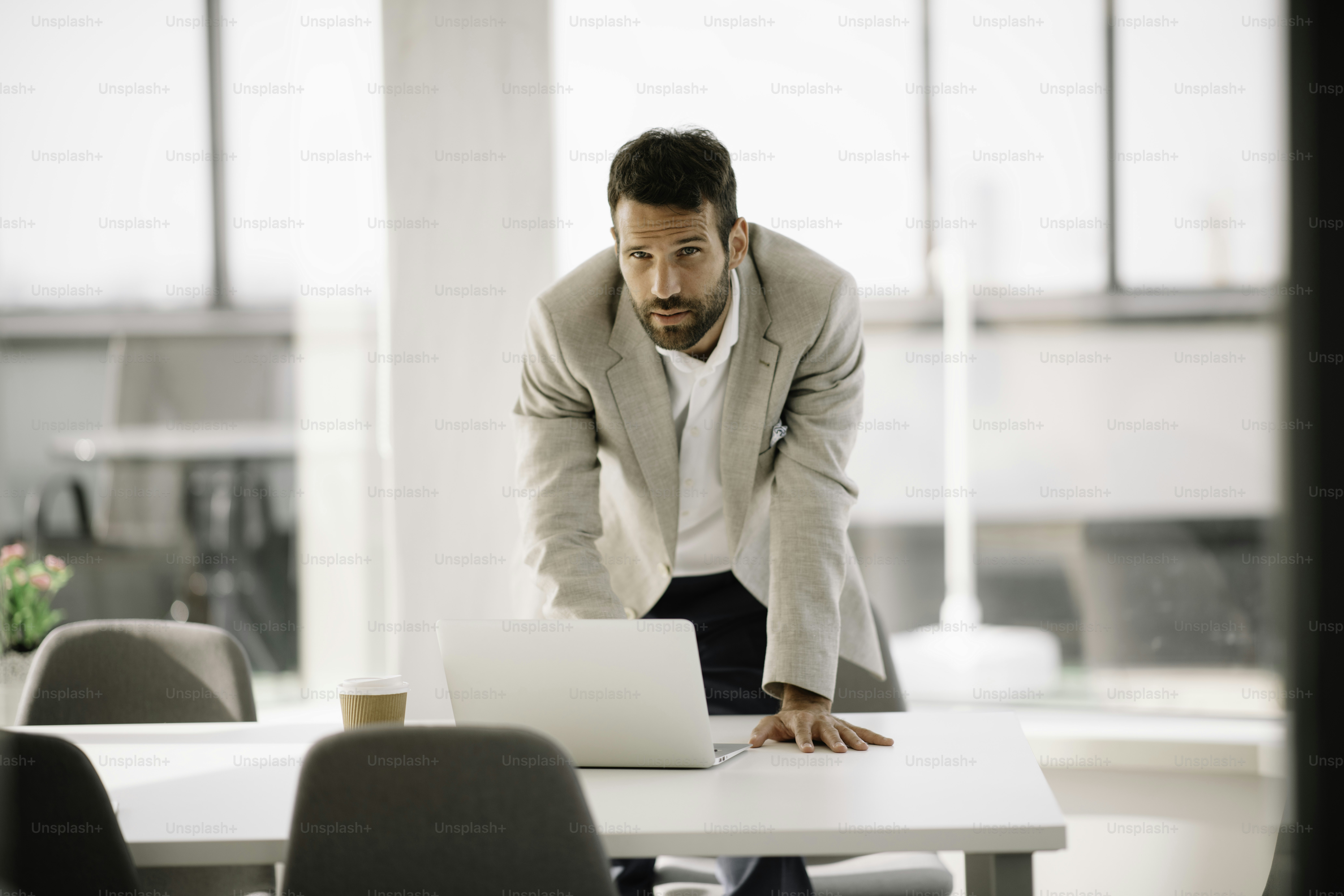 Handsome businessman working in office. Young man working on lap top ...