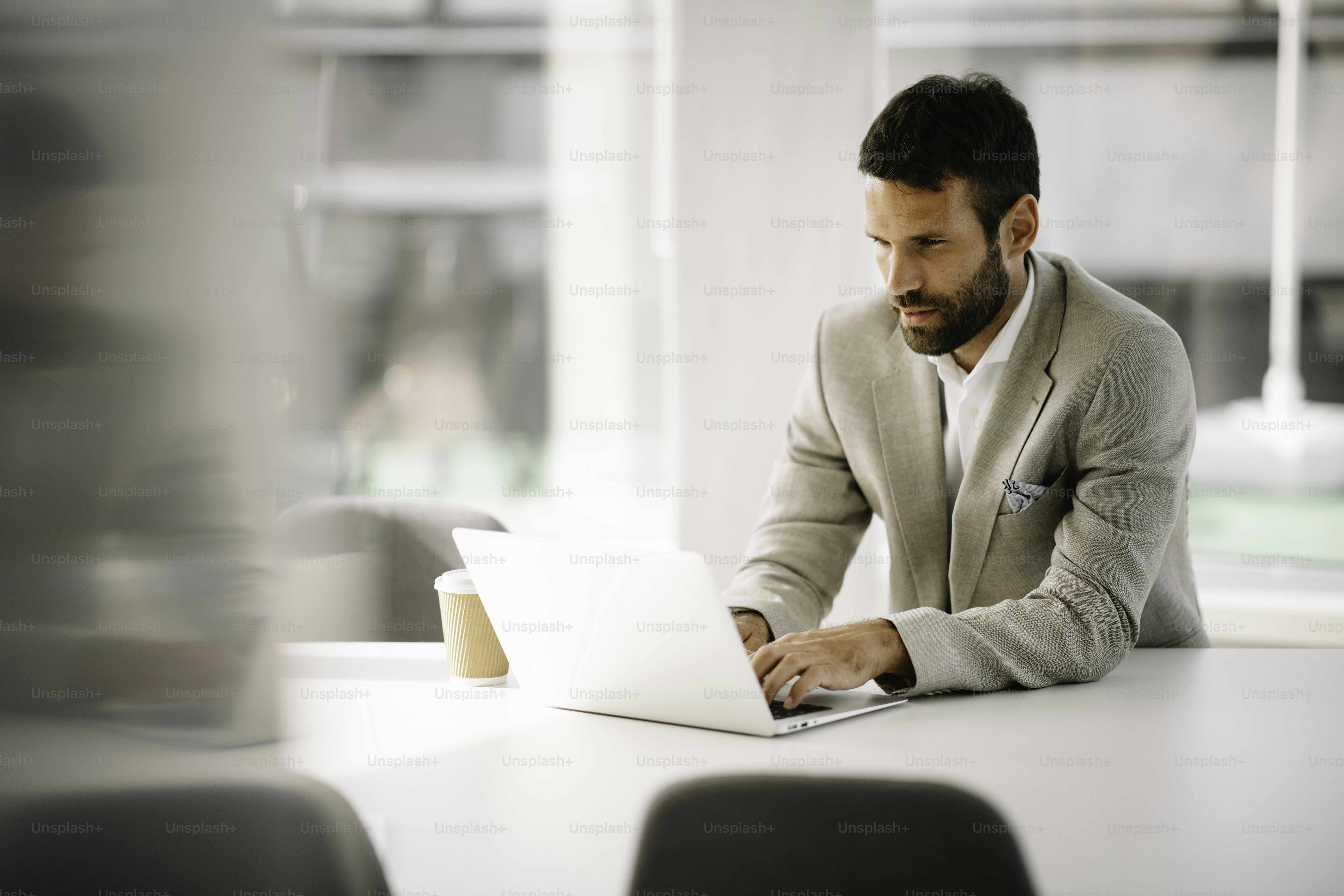 Handsome businessman drinking coffe and working on lap top. Young man ...