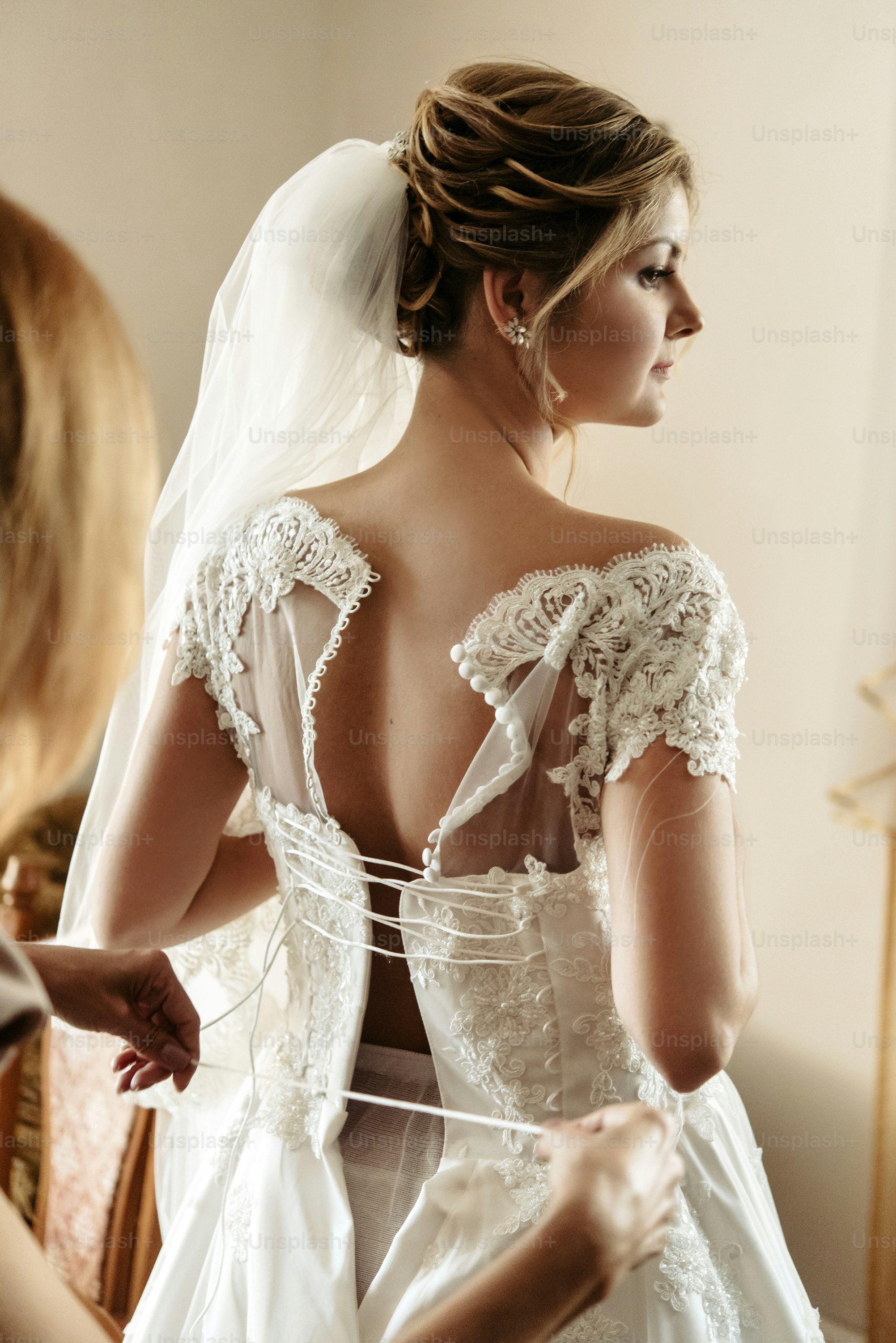 Luxury gorgeous blonde bride getting dressed in the morning with ...
