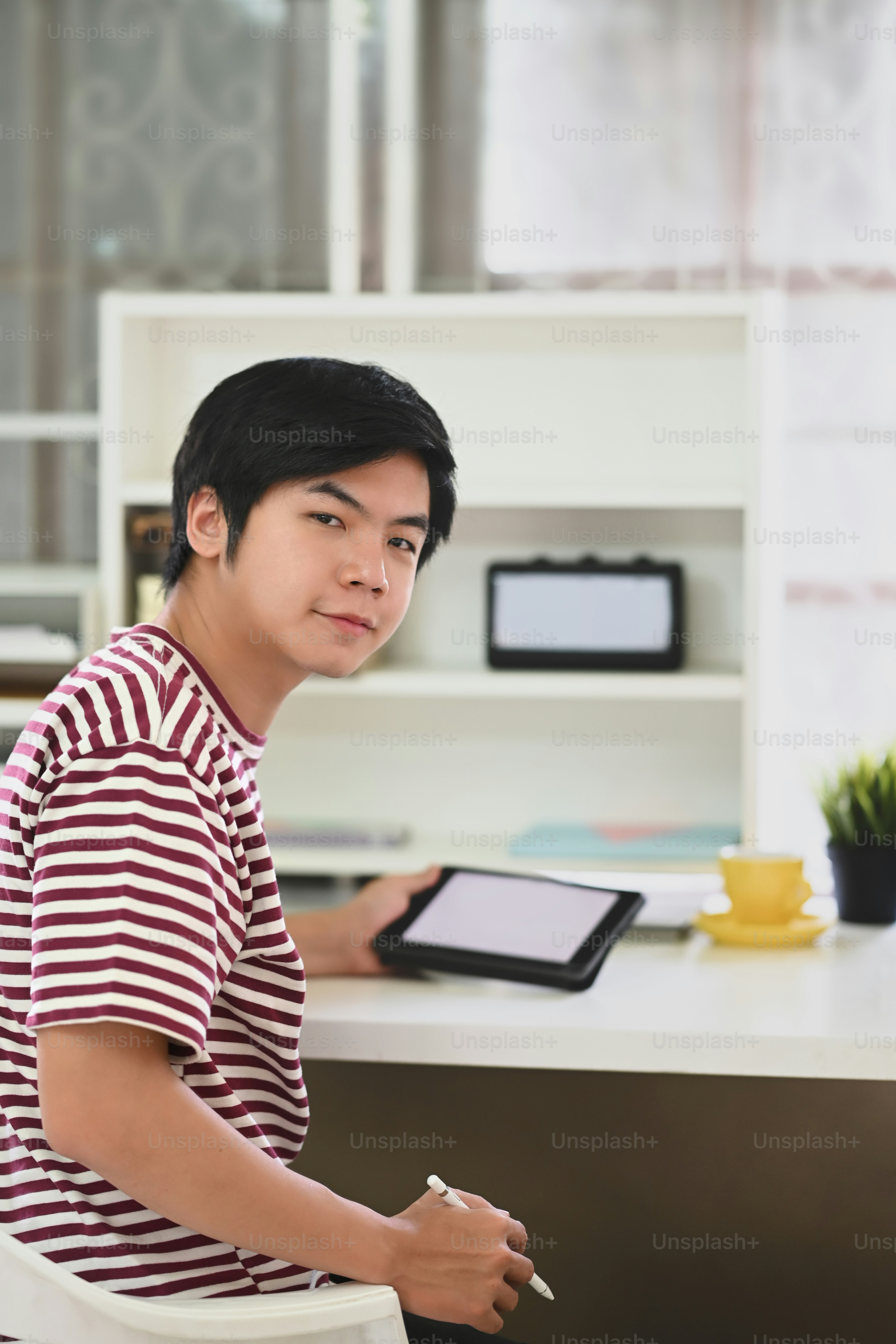 Photo of smart man in striped t-shirt working with computer tablet ...