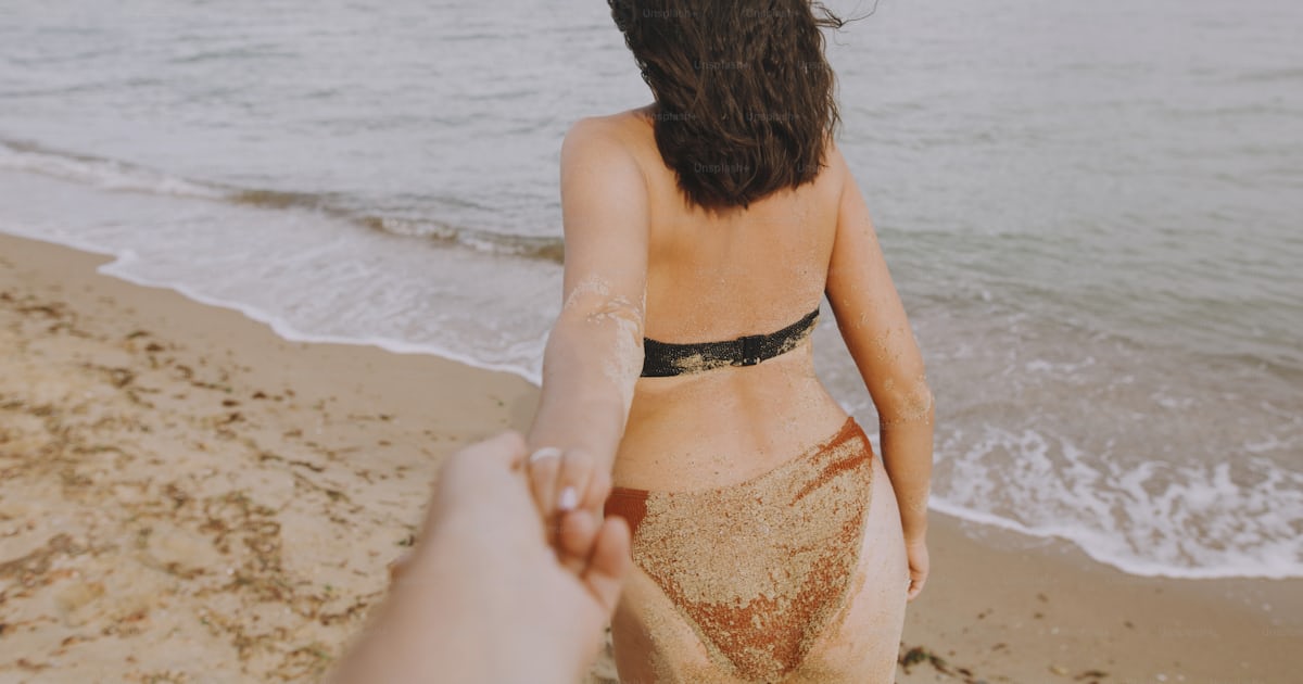 따라 오세요 해변에서 손을 잡고 남자를 이끄는 여자 여름 방학이나 신혼 여행에 사랑에 빠진 커플 남자의 손을 잡고 있는