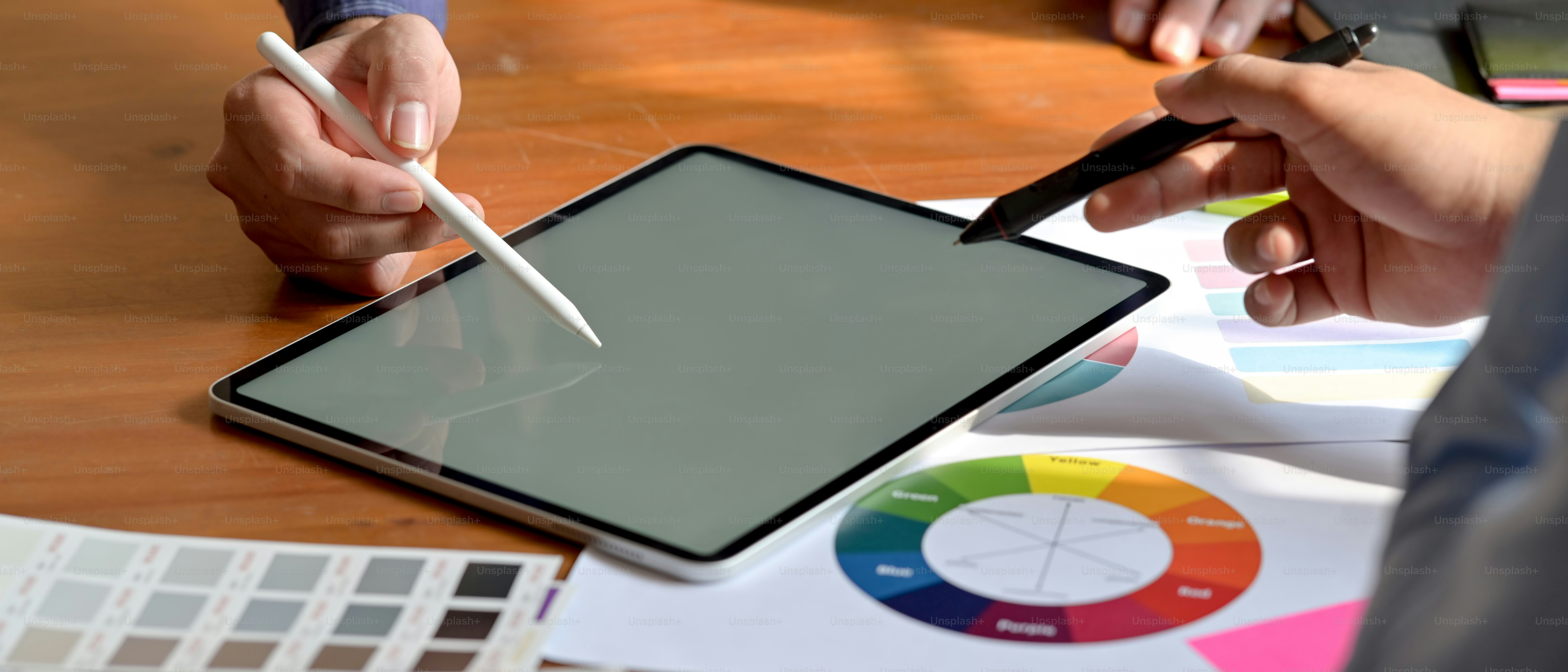 Cropped shot of two graphic designers working together with mock-up ...