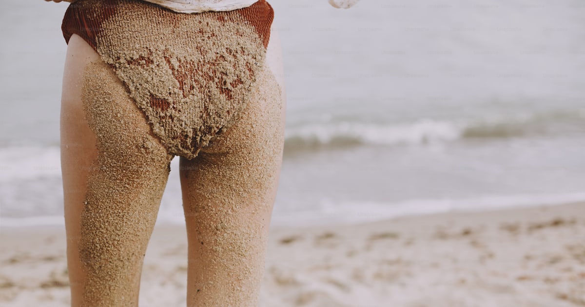 젊은 여자 엉덩이와 다리가 해변에서 닫힙니다 모래 수영복과 다리가 해변에서 휴식을 취하는 행복한 젖은 소녀 뒷모습 여름