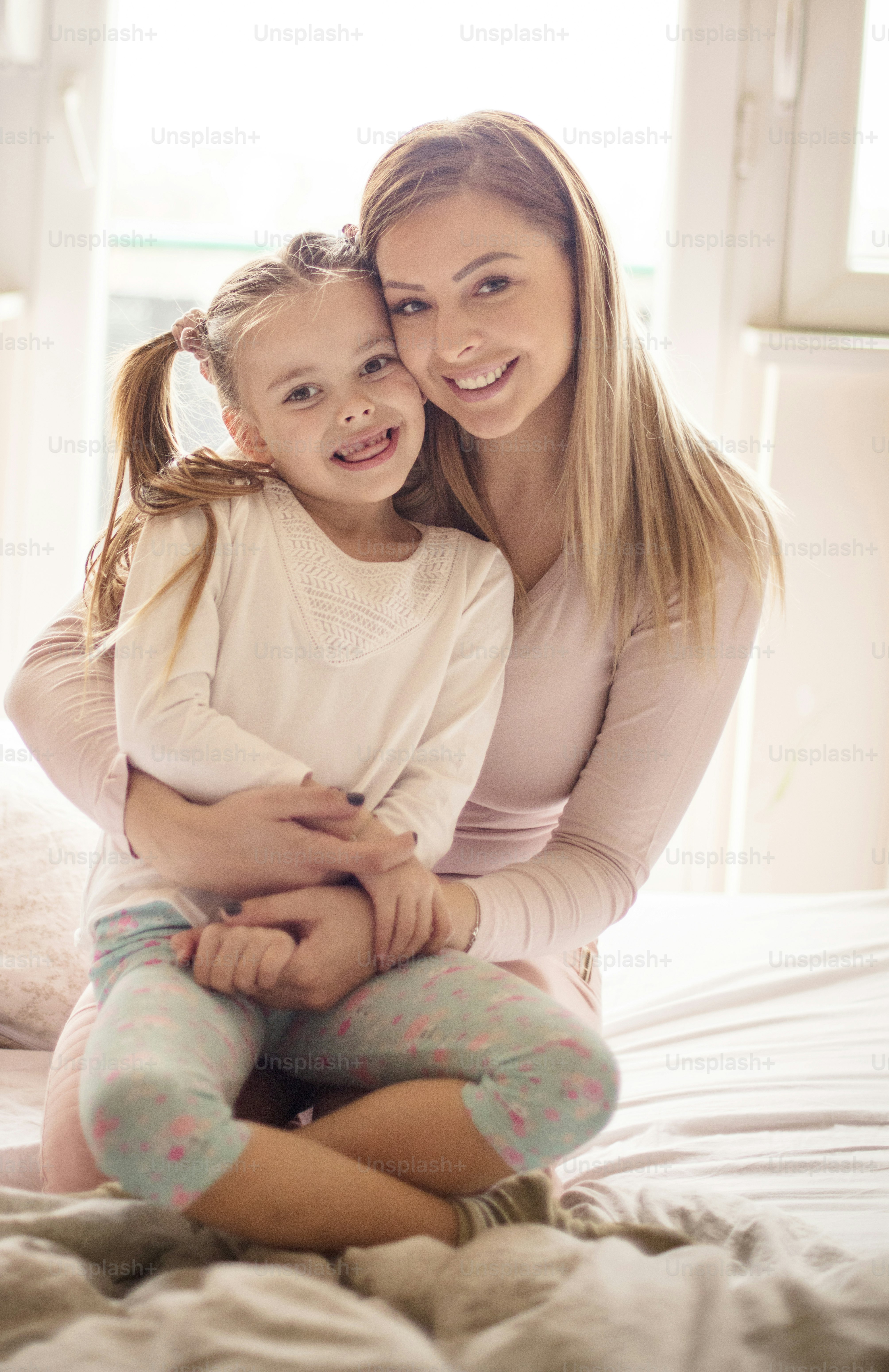 Familie ist ein Schatz. Mutter und Tochter im Bett. Foto – Bild zum ...