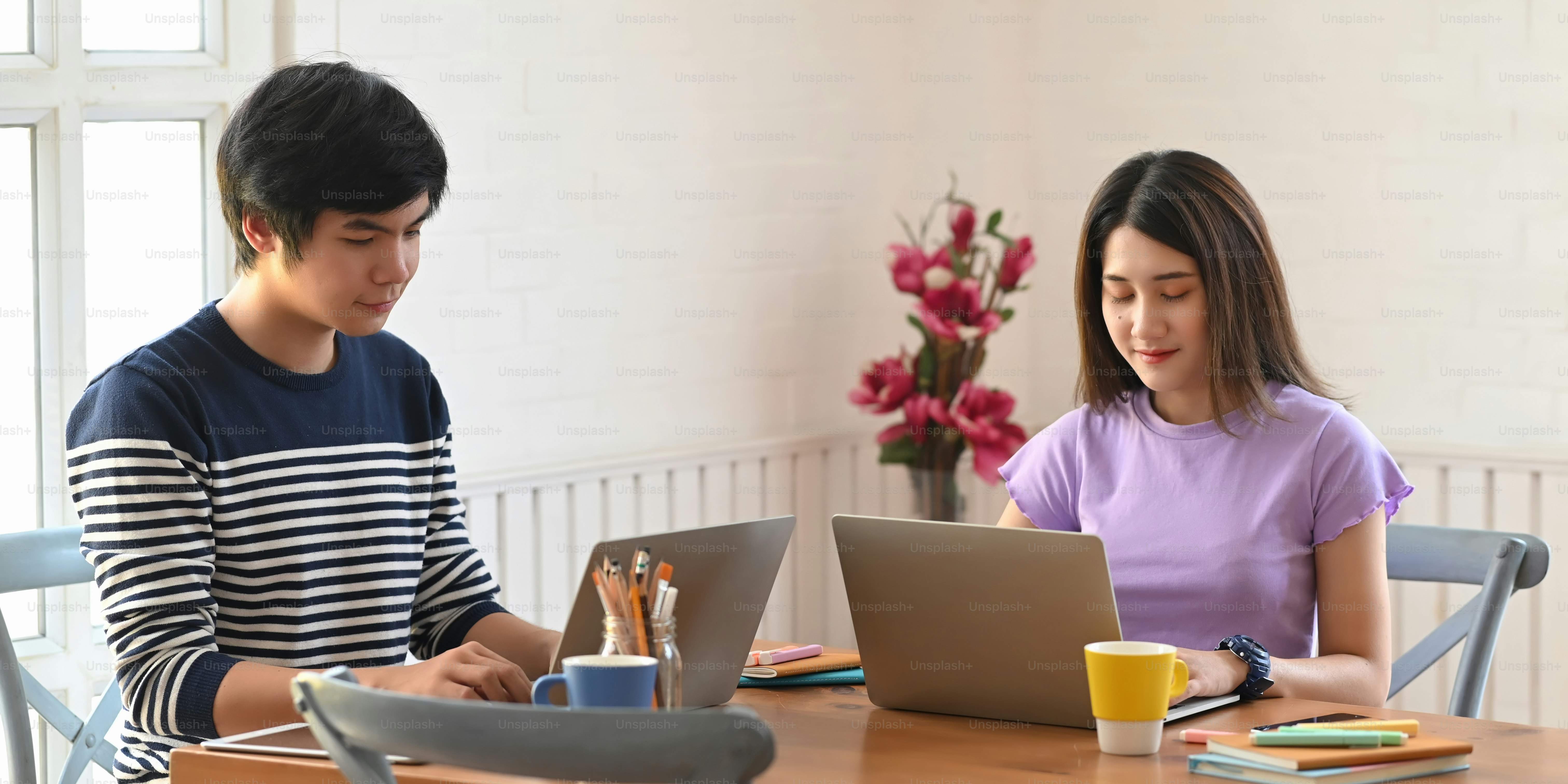 Young couple working with computer laptop and tablet while sitting ...