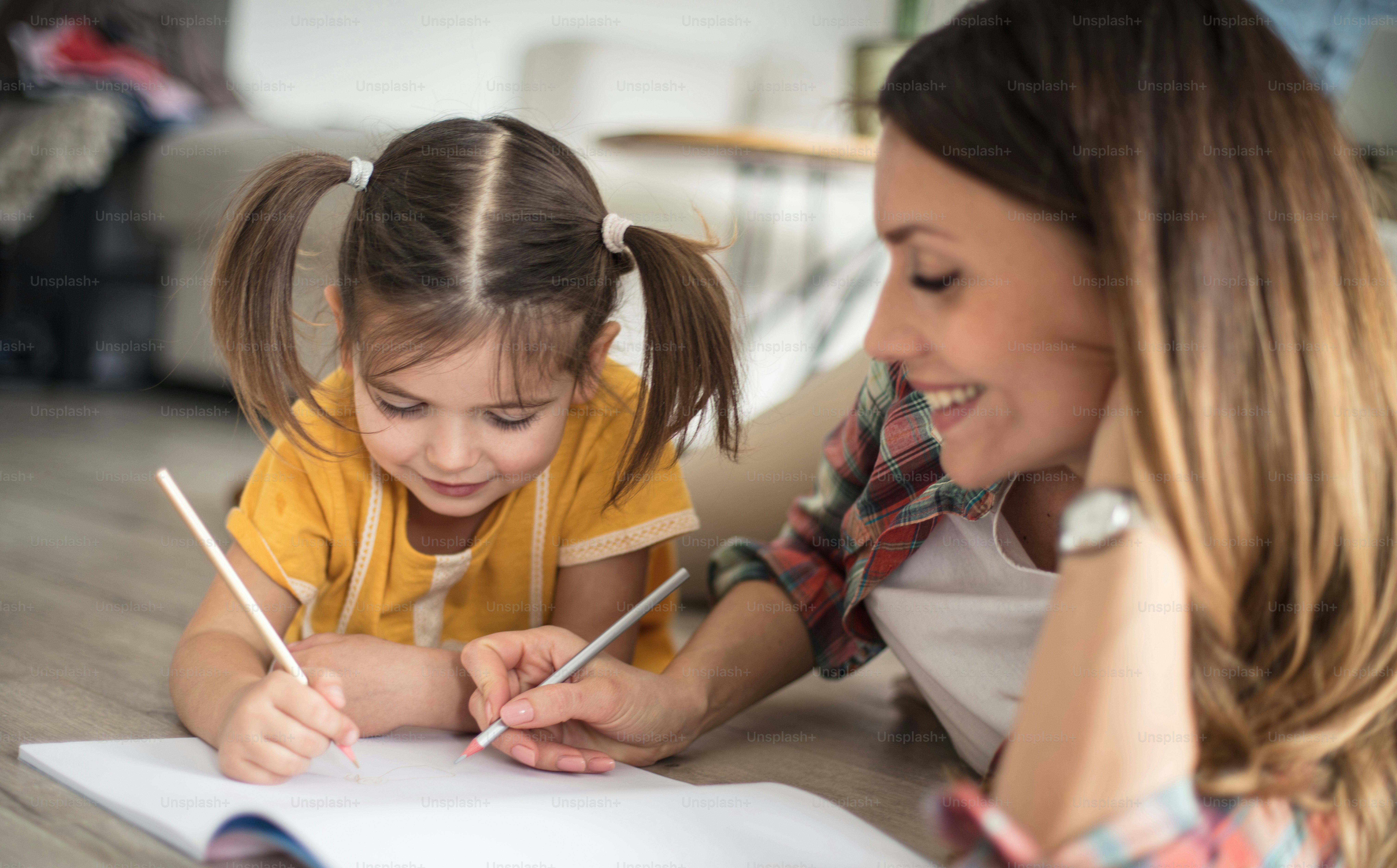 Foto Mira cómo lo hace mami. Madre ayudando a su hija con la tarea ...