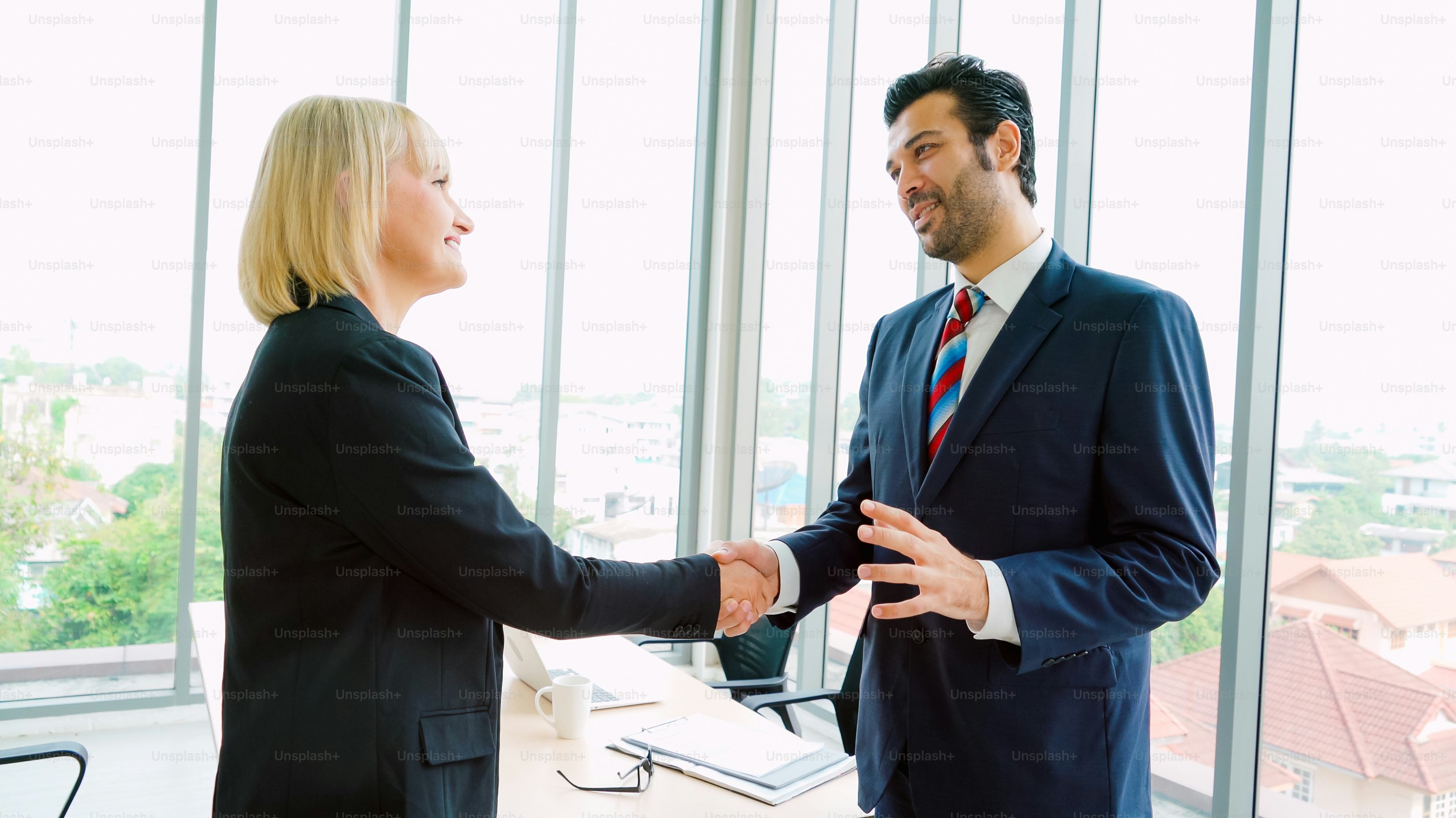 Des gens d’affaires se serrent la main dans un bureau d’entreprise montrant un accord ...