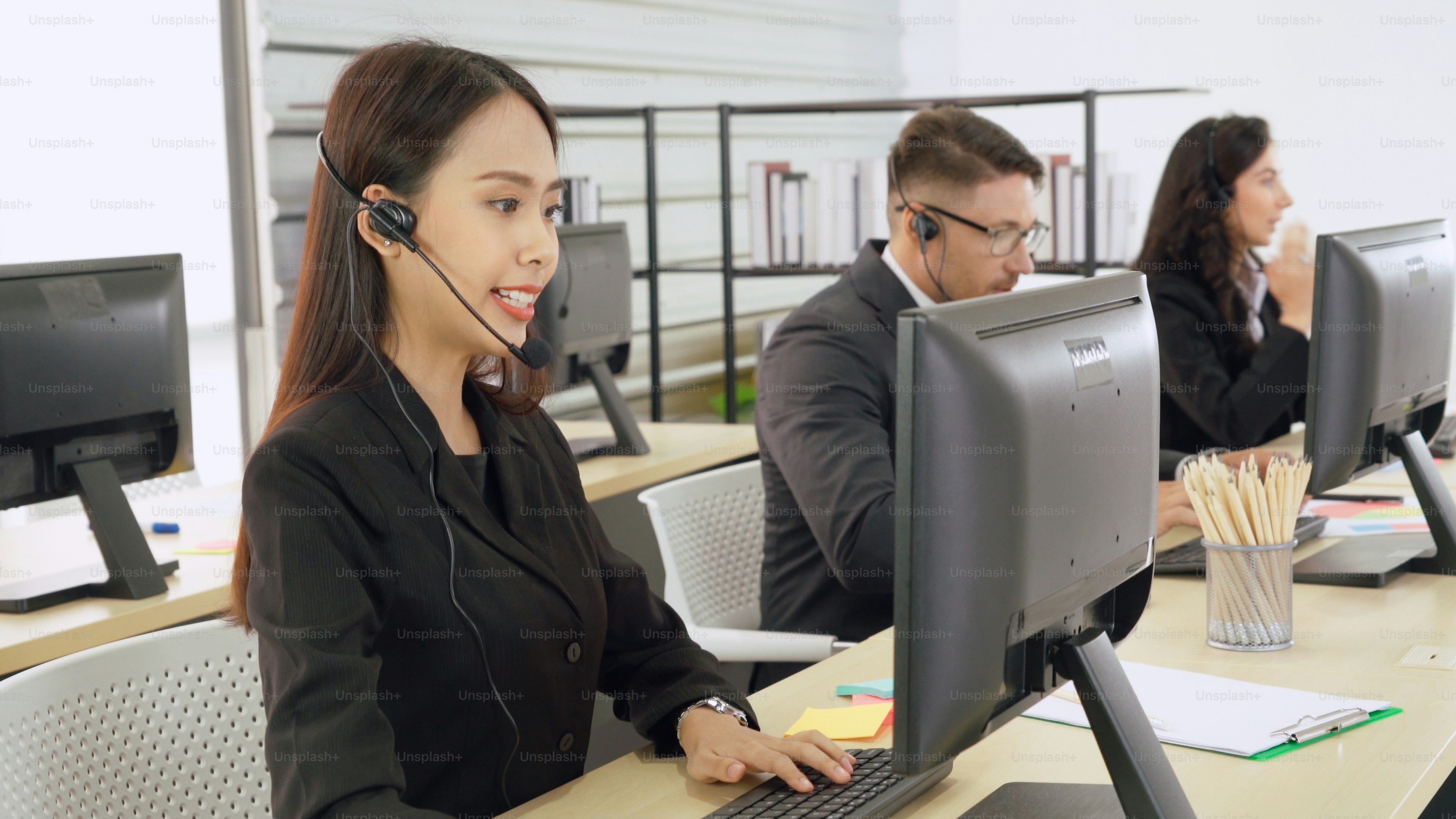Business people wearing headset working in office to support remote ...