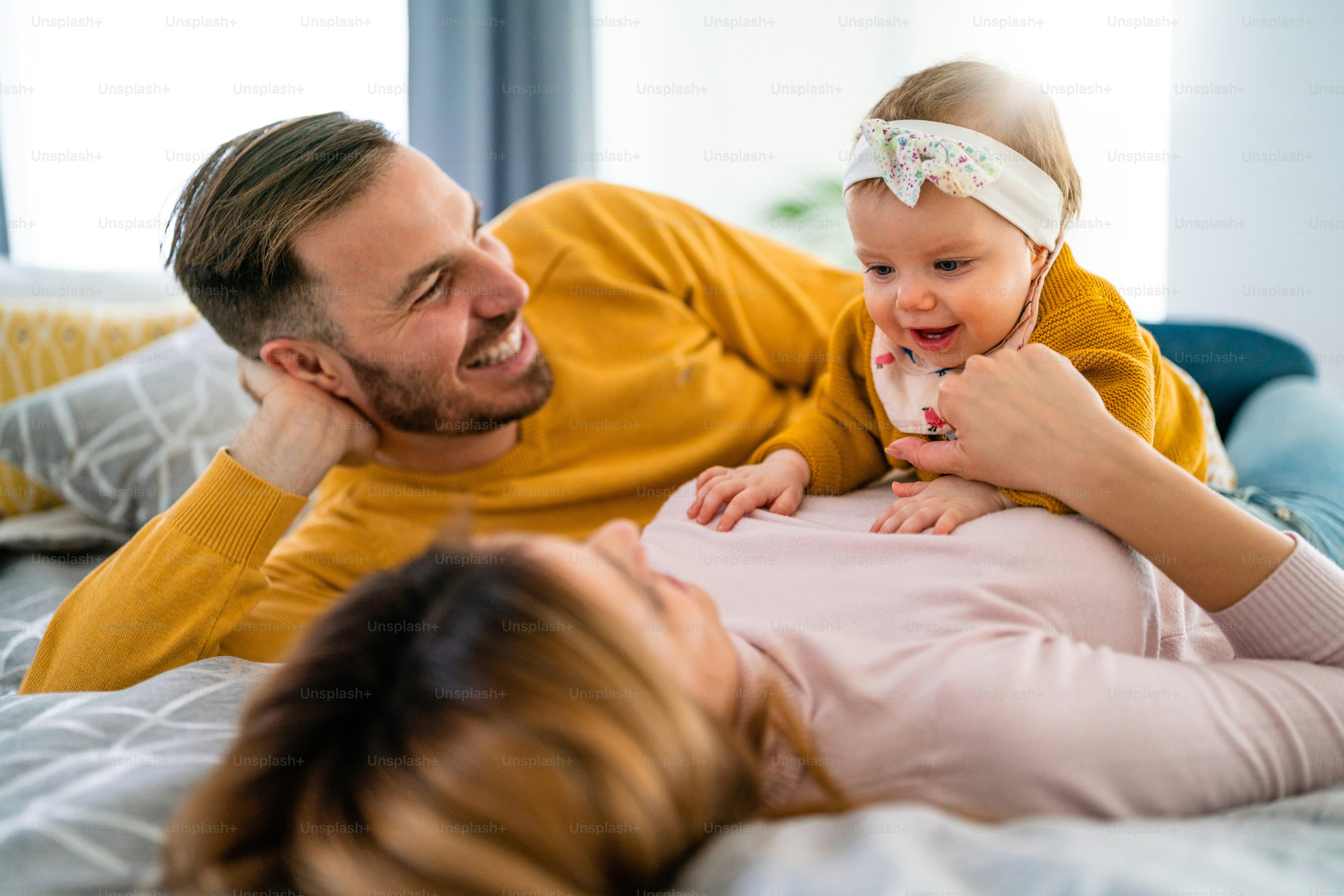 Happy parents enjoying playing with baby girl at home photo – Small ...