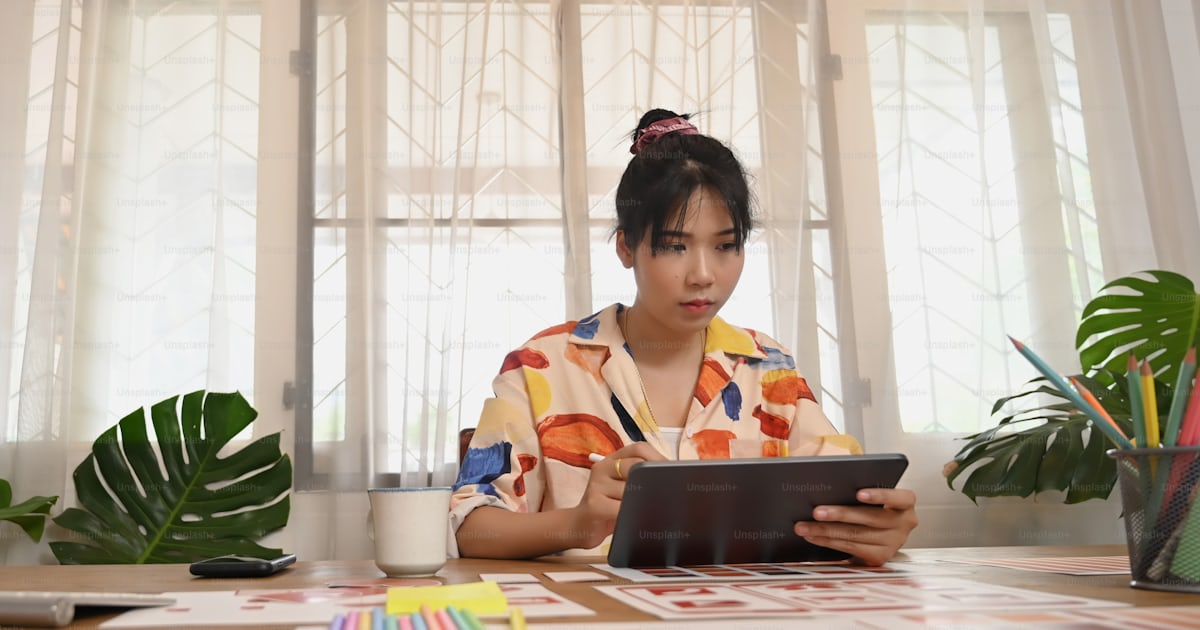 Ux Ui Developer Is Working With A Computer Tablet While Sitting At The