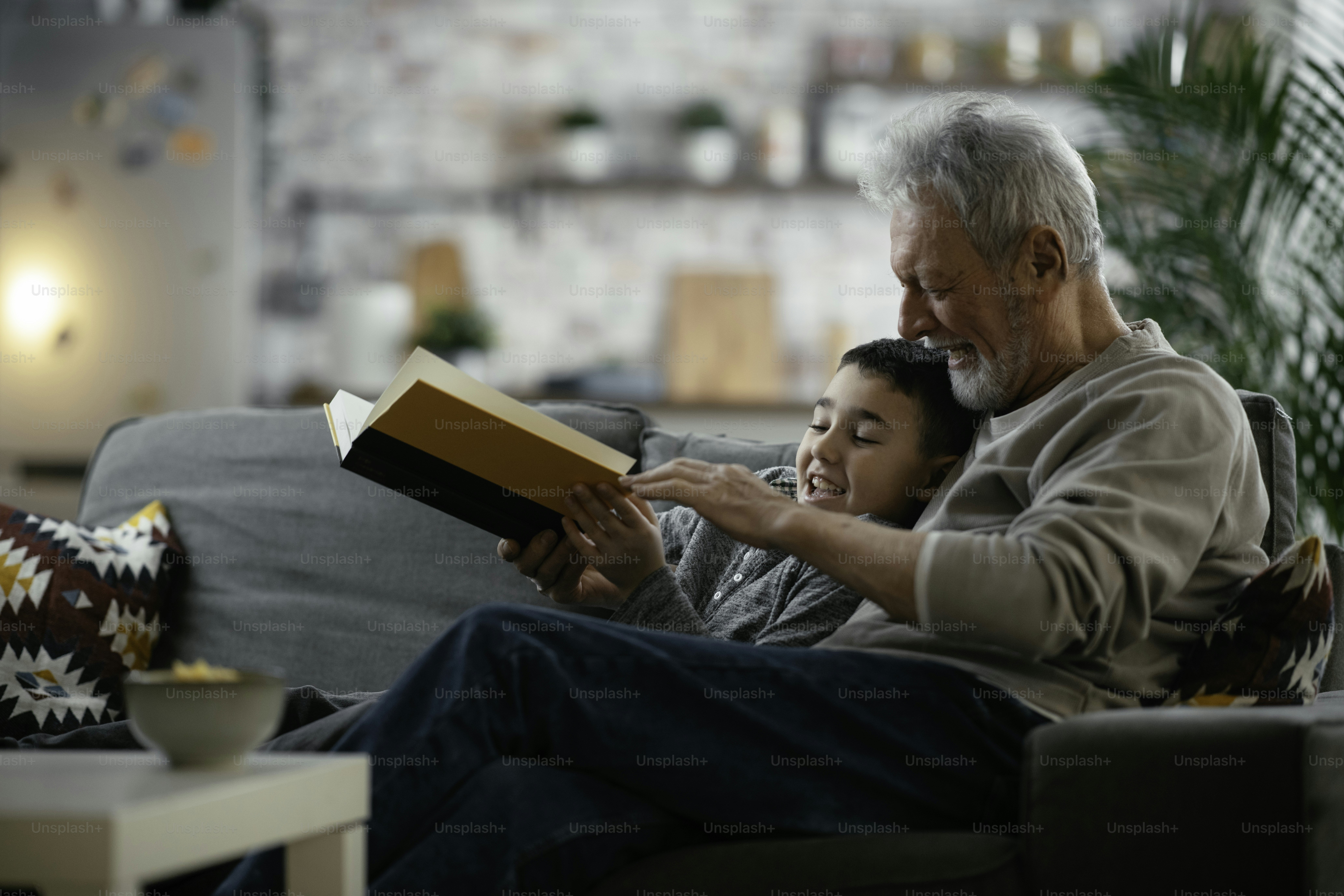 Grandfather and grandson reading a book. Grandpa and grandson enjoying ...