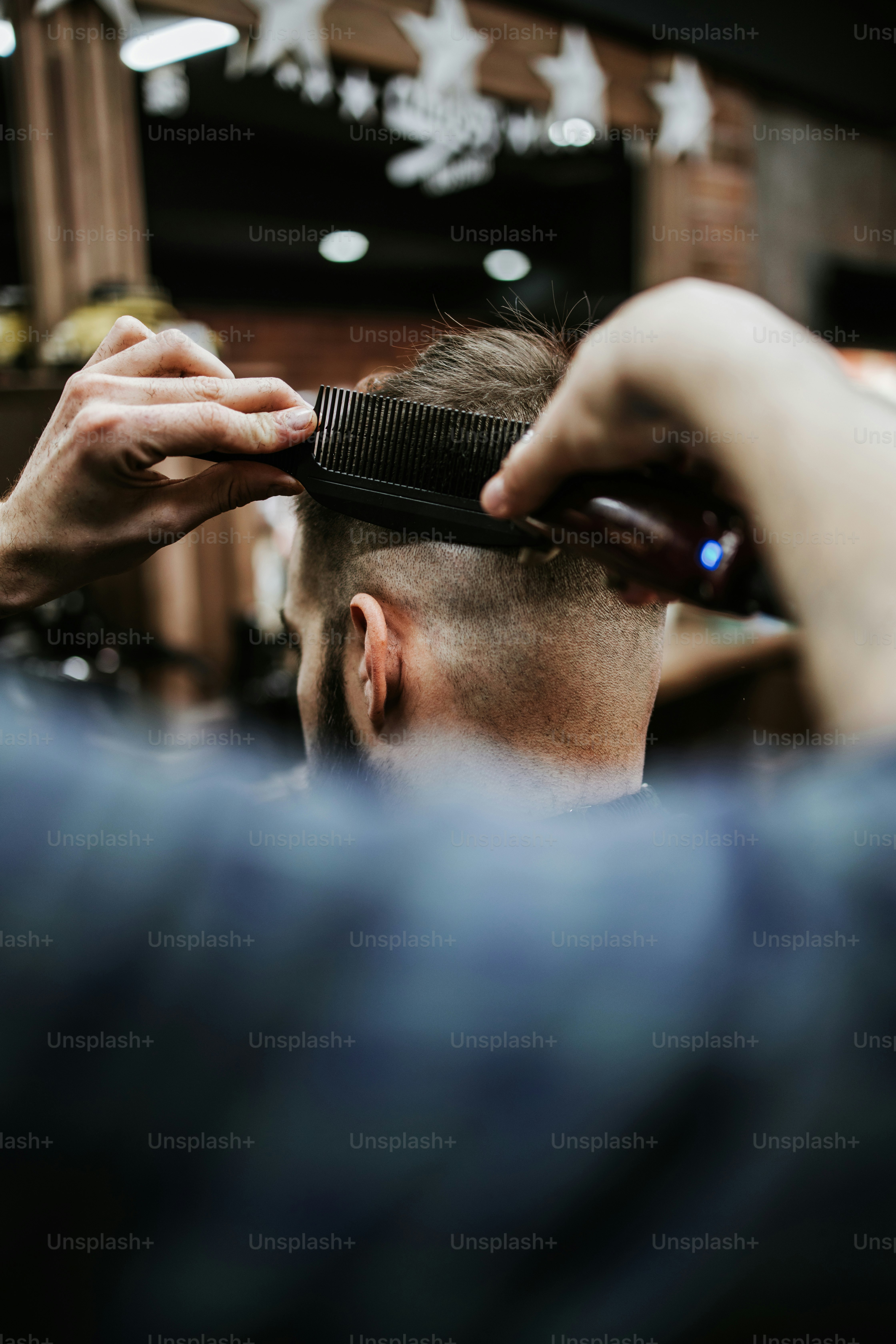 Good looking young adult man getting a hair and beard styling and ...