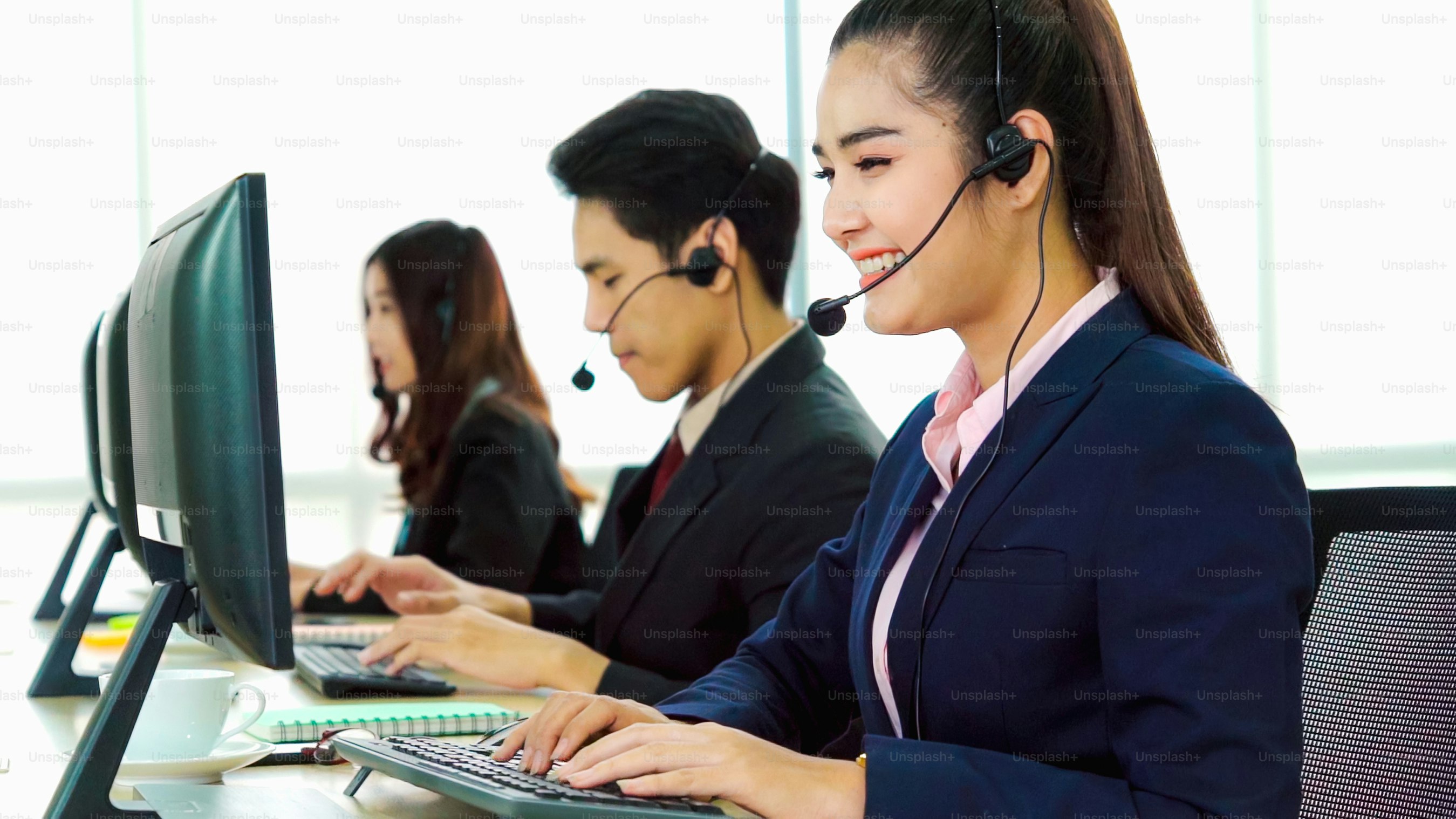 Business people wearing headset working in office to support remote ...