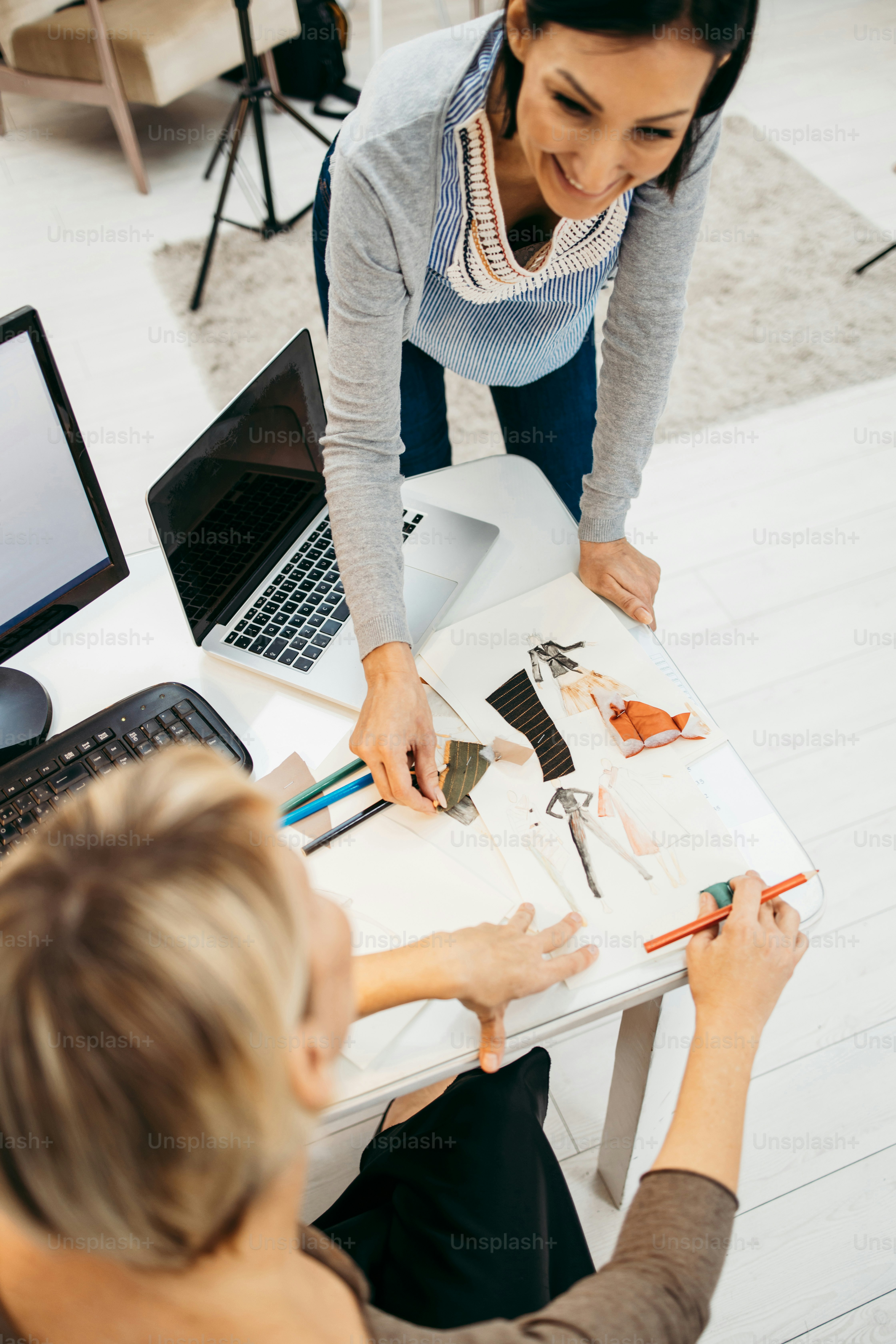 Two professional designers working in fashion studio. Creative people ...