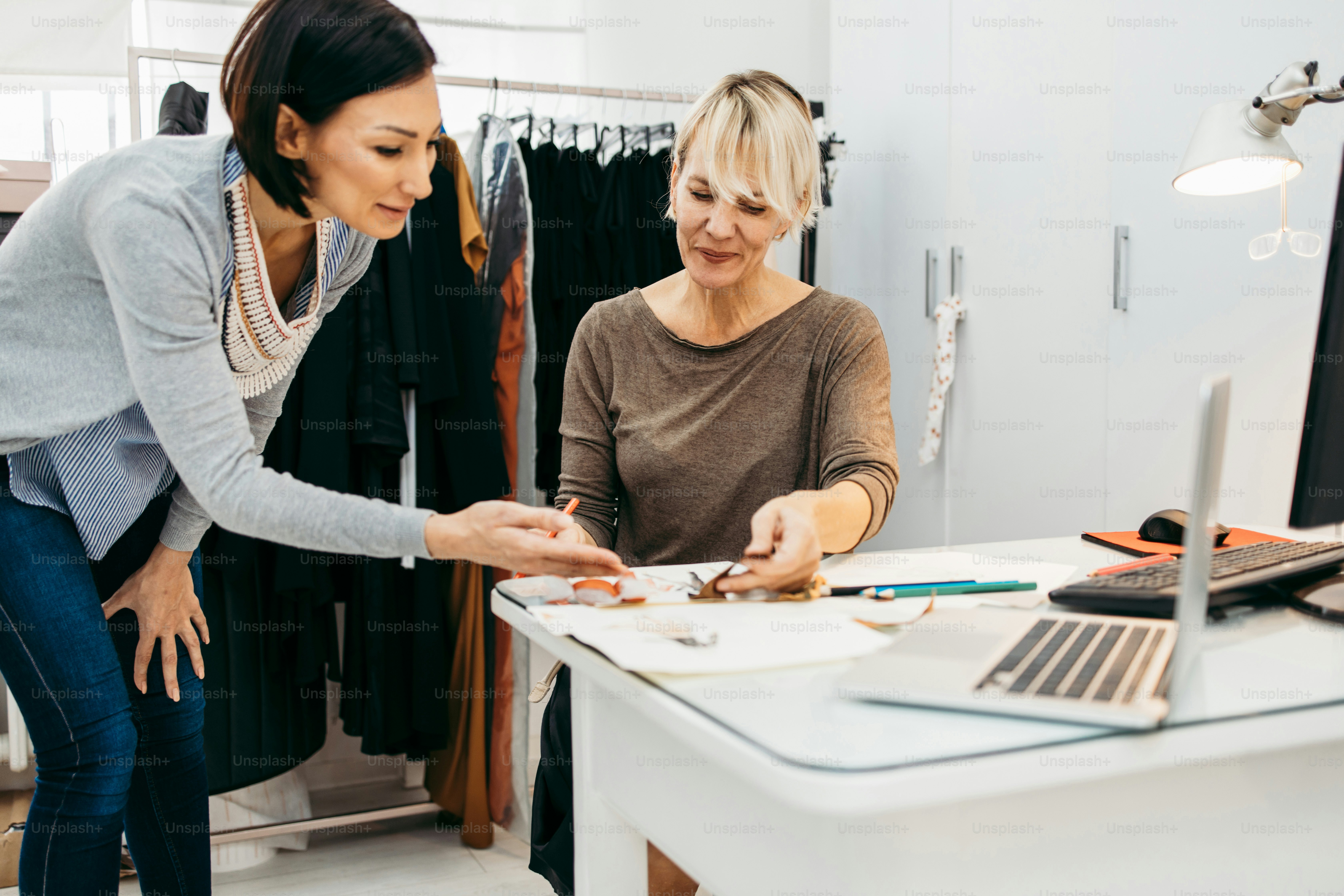 Two professional designers working in fashion studio. Creative people ...
