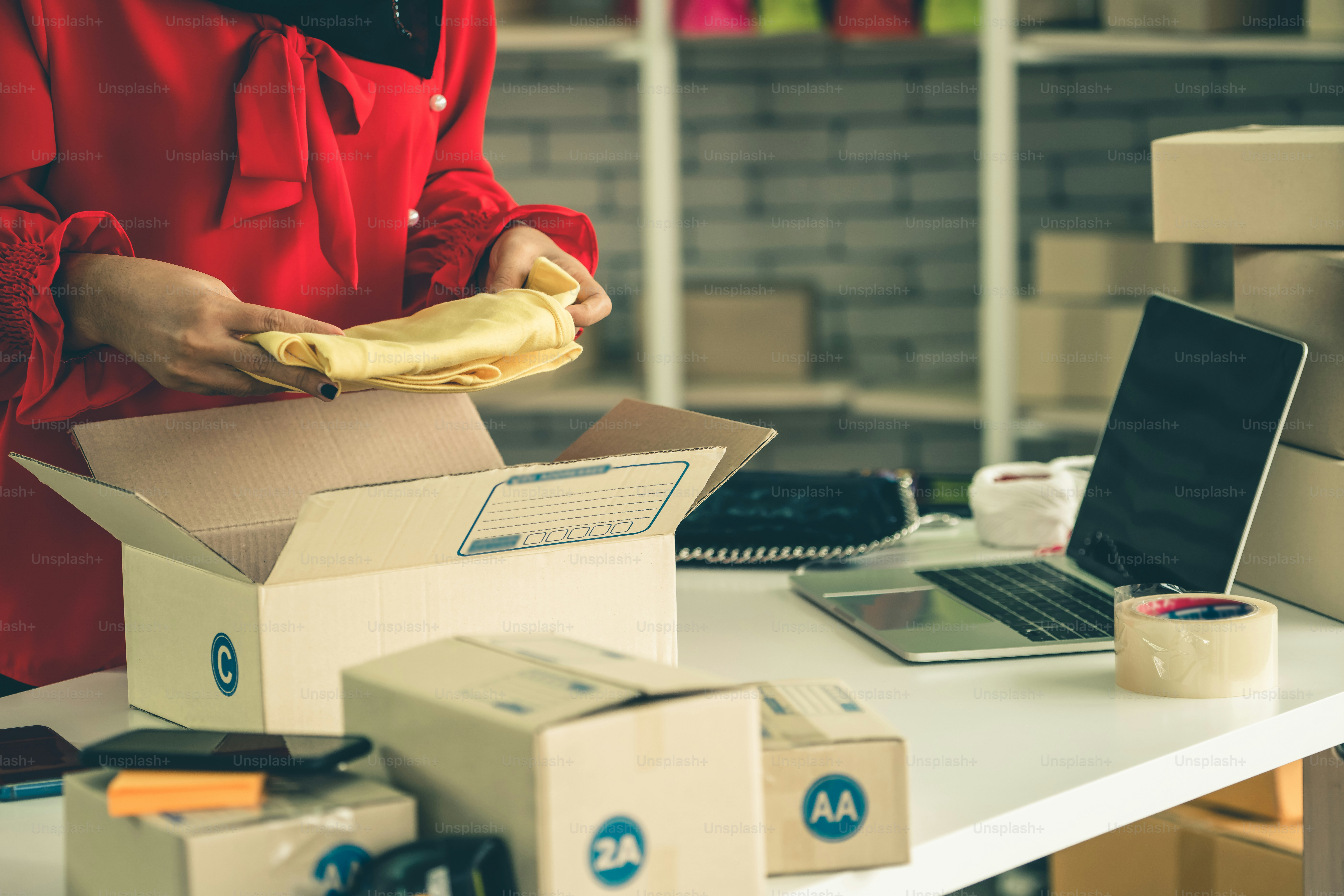Online seller works at home office and packs shipping delivery box to ...