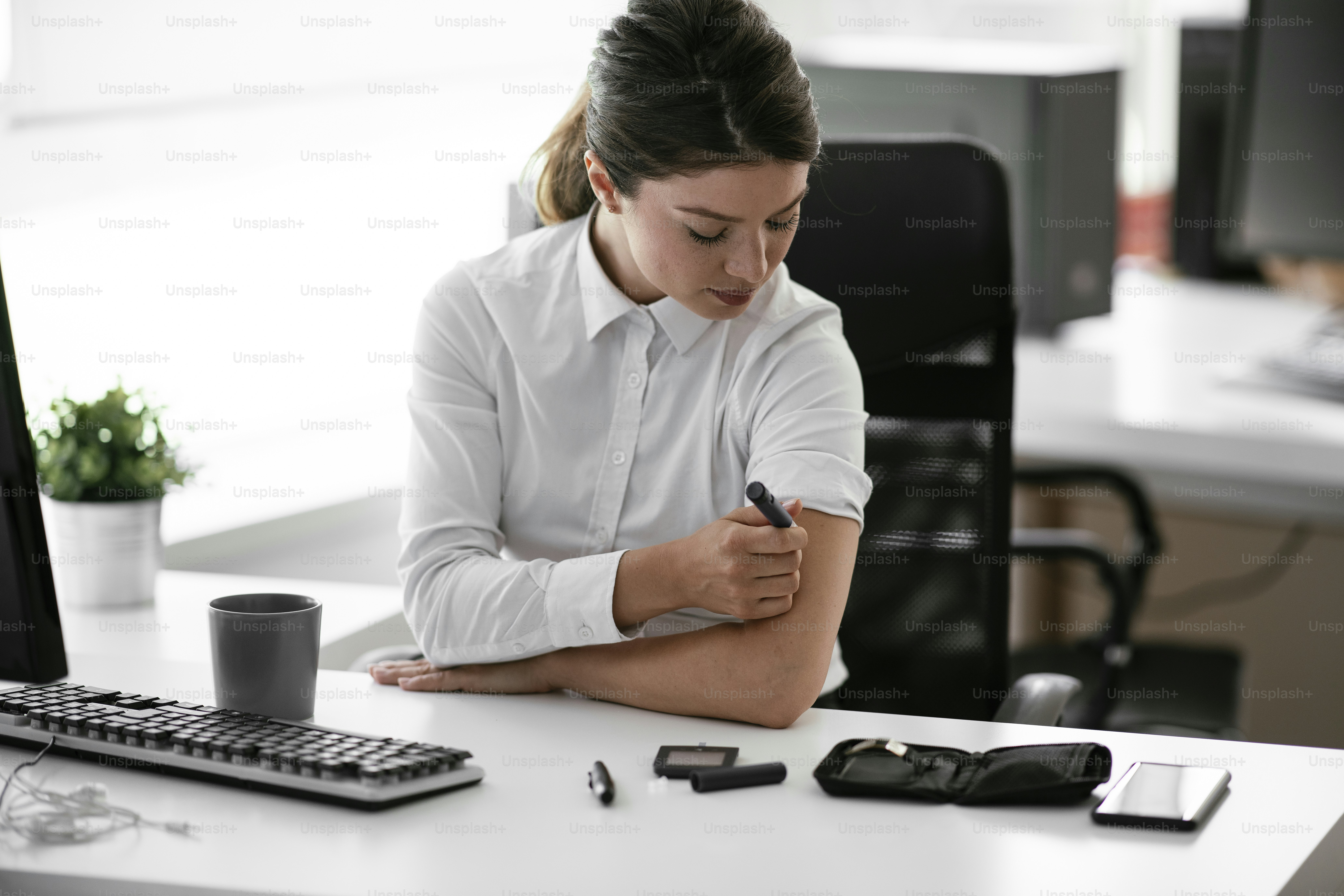 Businesswoman giving herself an injection of insulin. photo – Desk ...