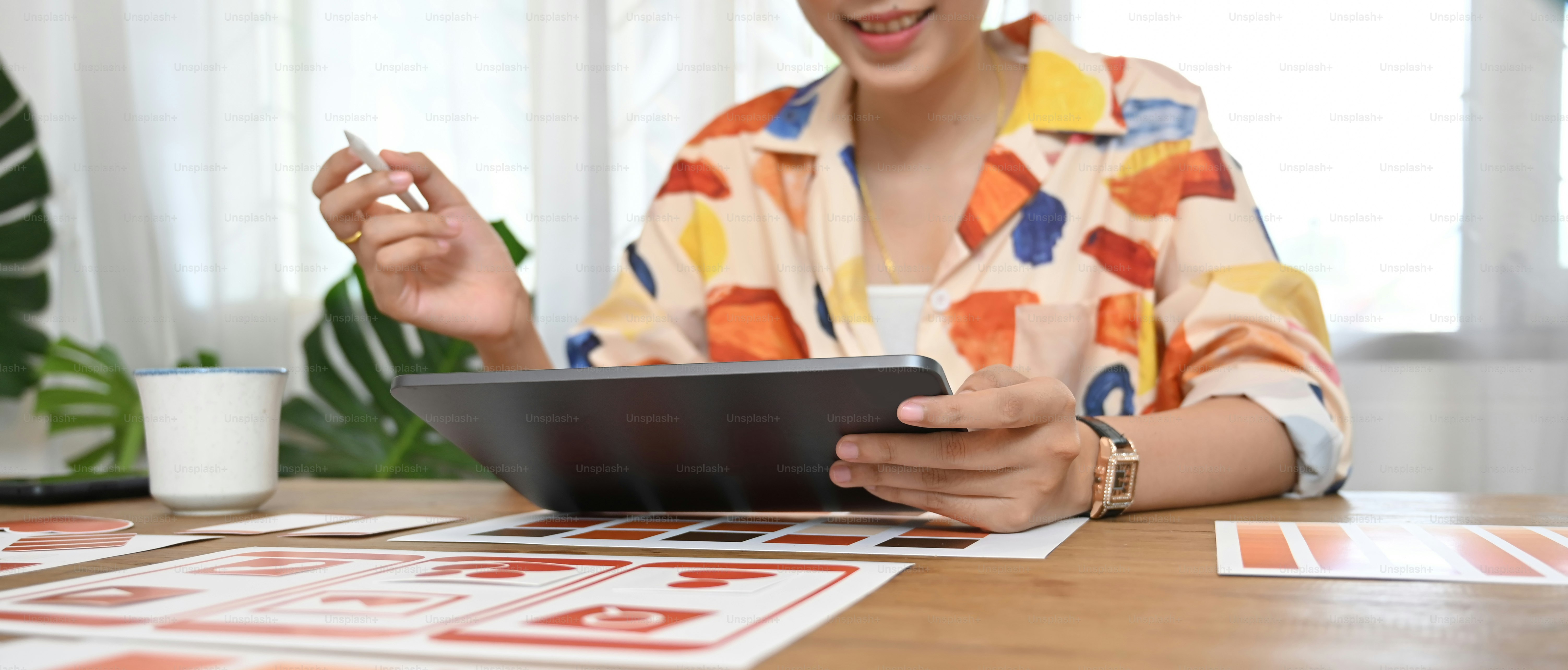 A graphic developer is using a computer tablet and stylus pen at the ...