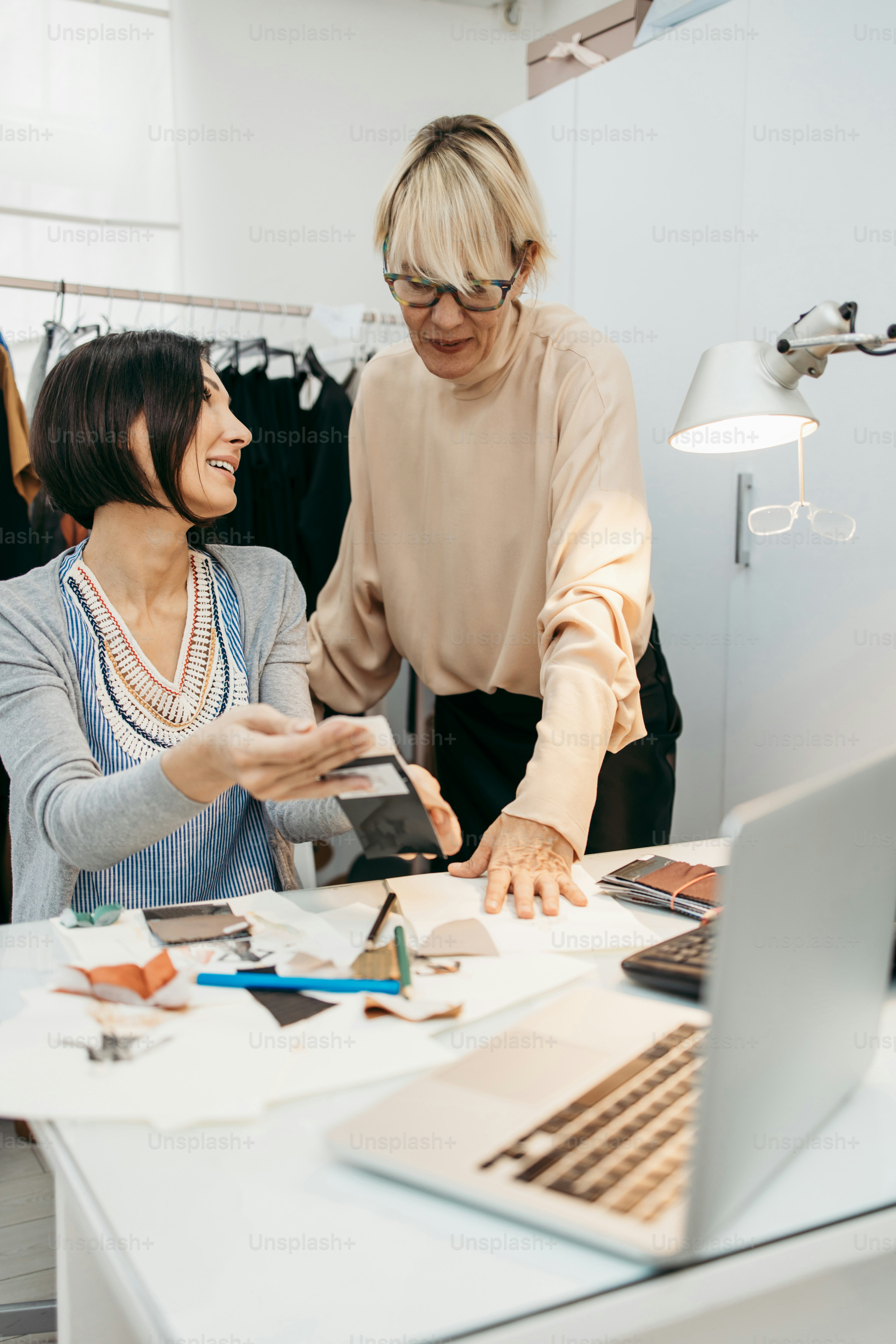 Two professional designers working in fashion studio. Creative people ...