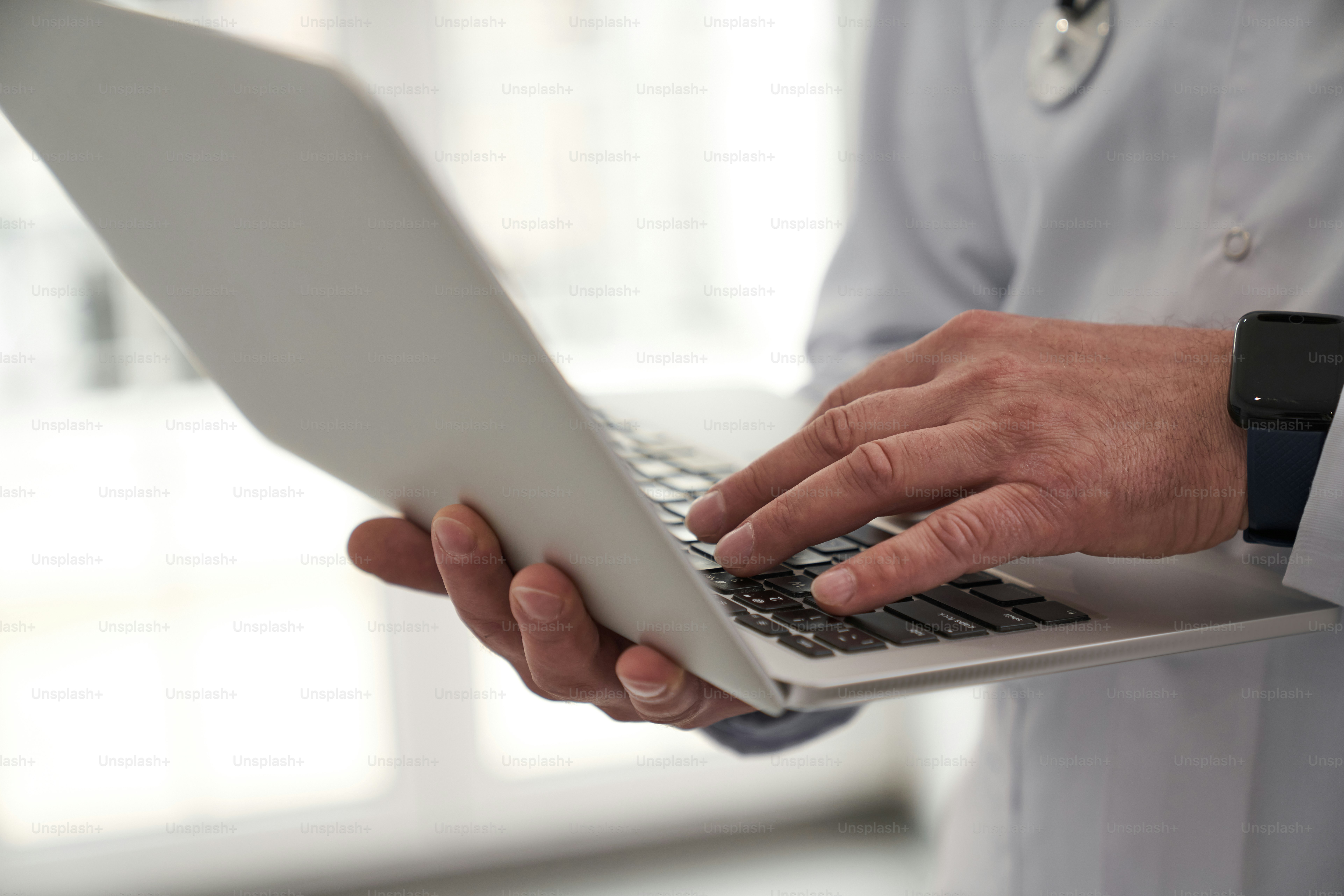 Close up cropped head of general practitioner typing on notebook while ...