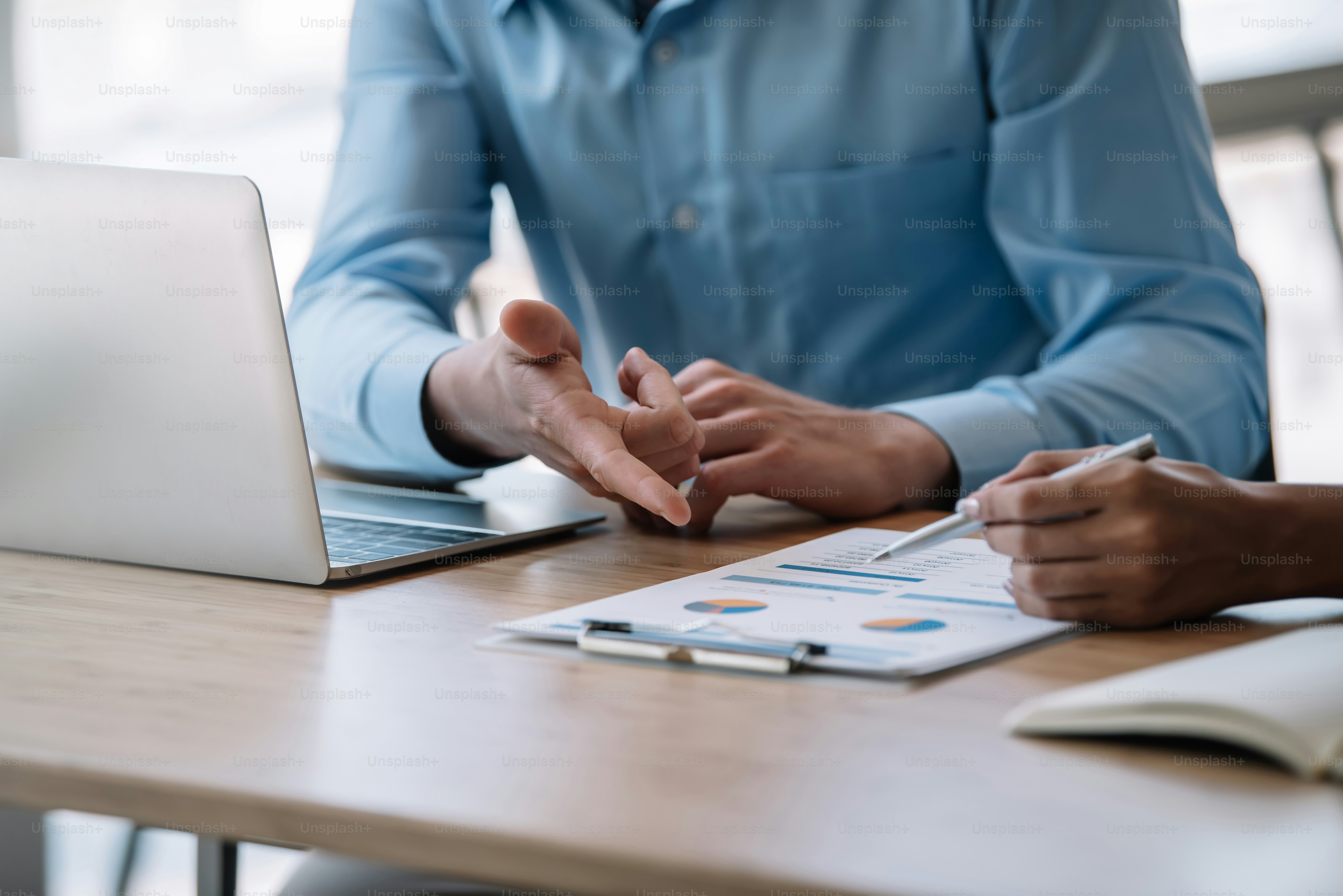 Business people pointing financial data graph on the table in the ...
