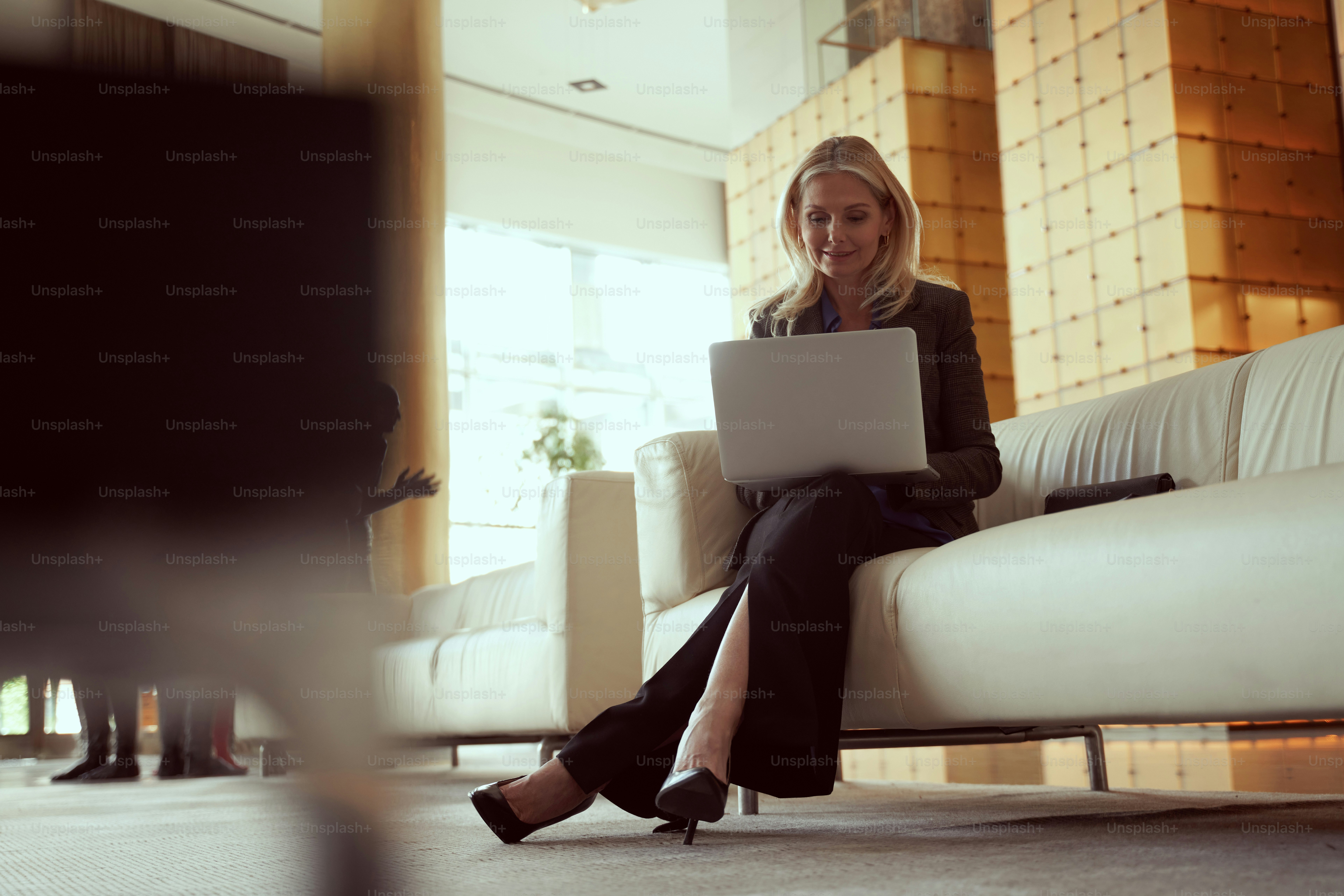 Motivated lady wearing high heels sitting cross-legged working on her ...