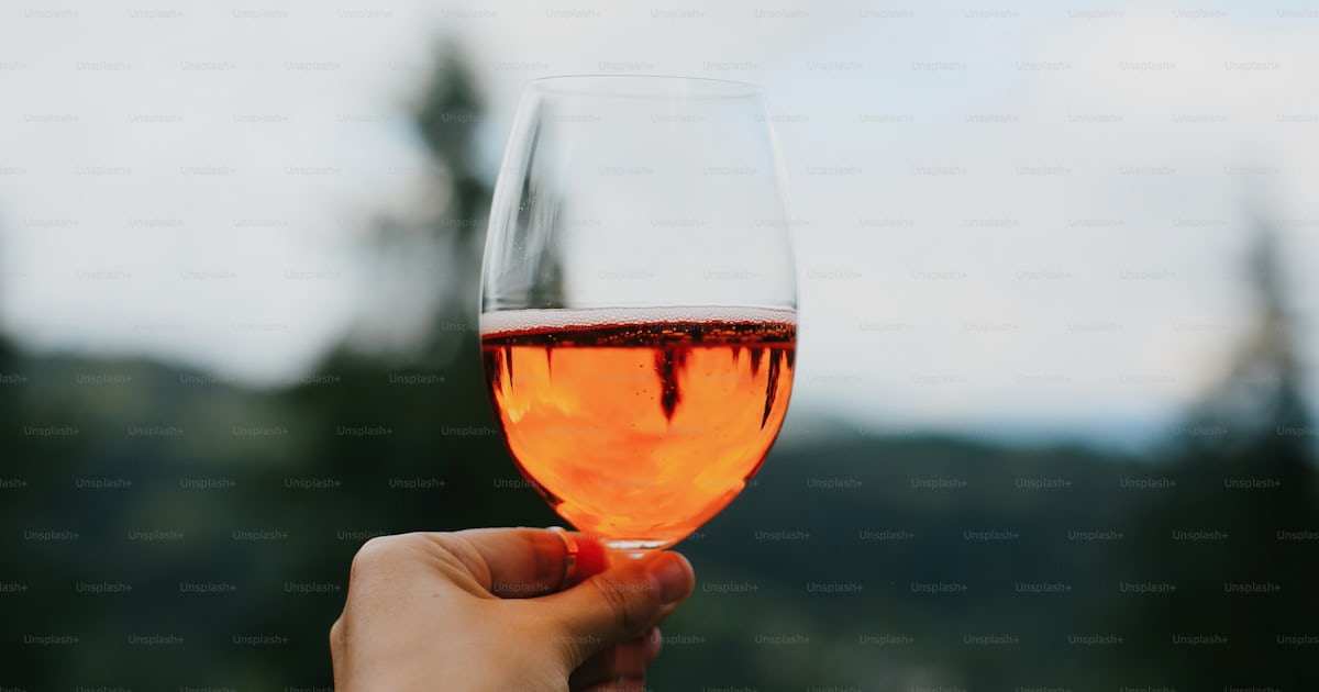 Aperol 음료는 산 여름 휴가 및 리조트를 배경으로 손에 있습니다 맛있는 오렌지 칵테일로 환호하는 여자 야외에서 축하