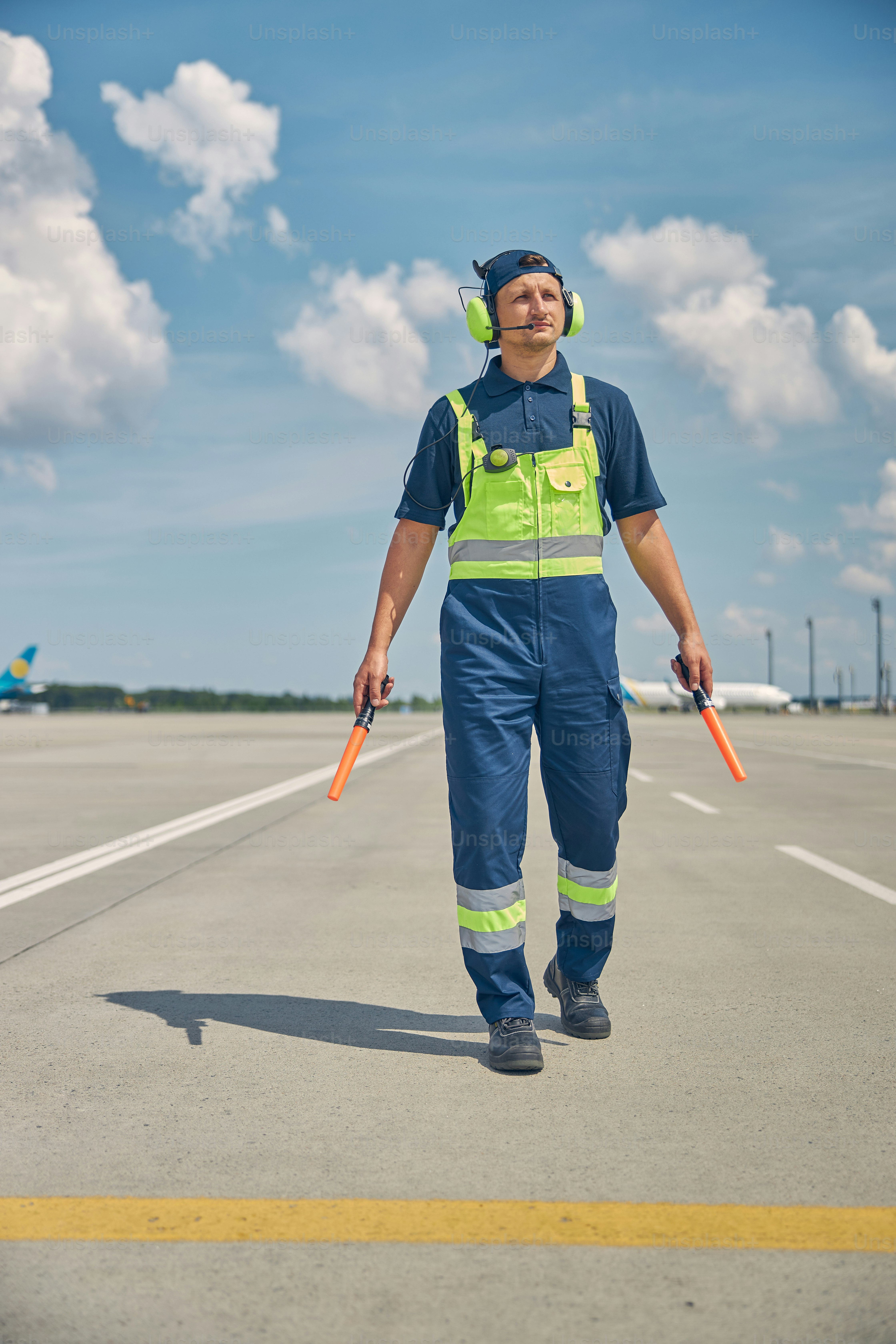 Full-length portrait of an aircraft marshaller with a pair of wands ...