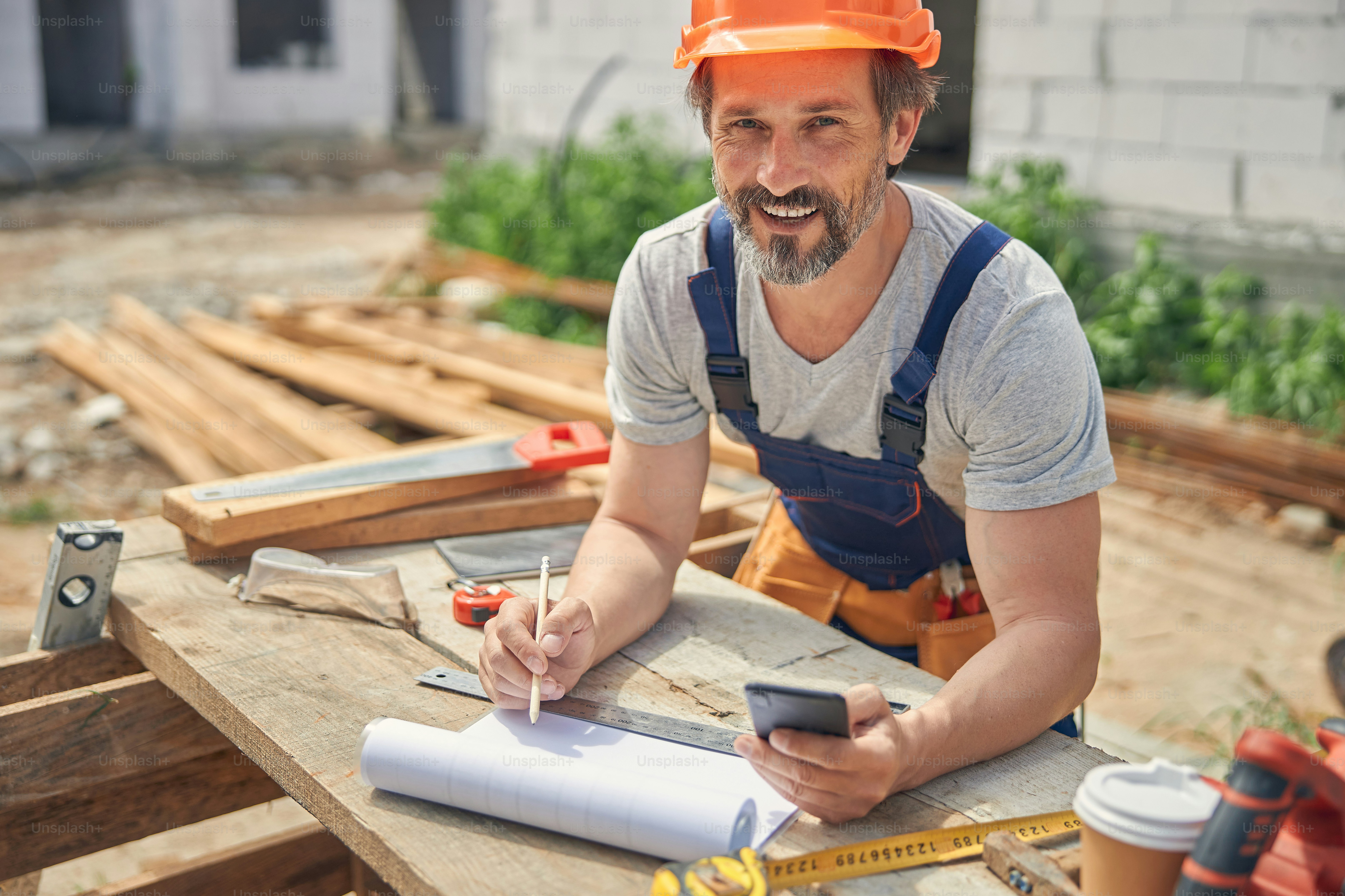 Foto Vista frontal de un alegre ingeniero constructor apoyado en ambos ...