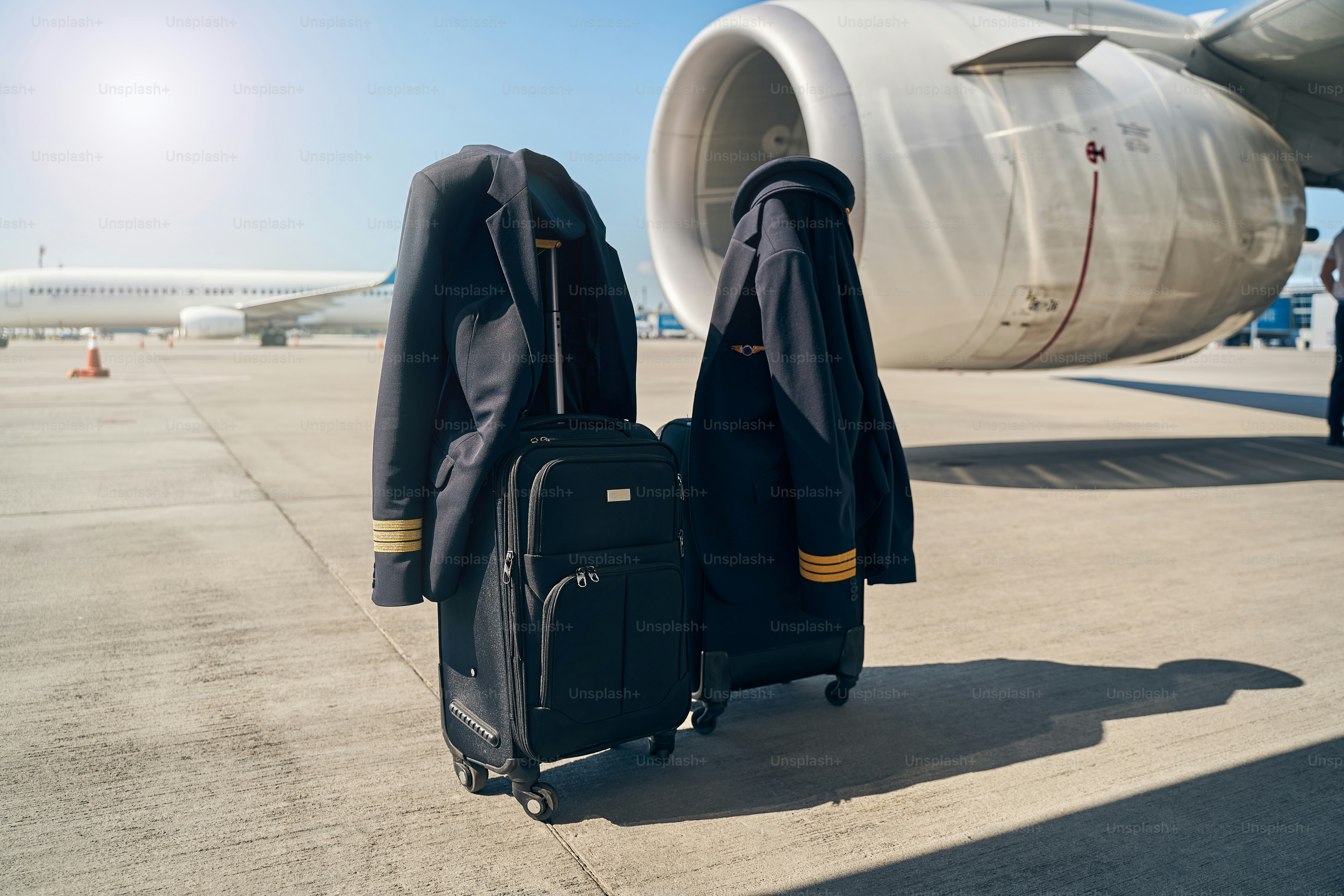 Foto Dos pares de chaquetas y gorras colgadas de las asas retráctiles ...