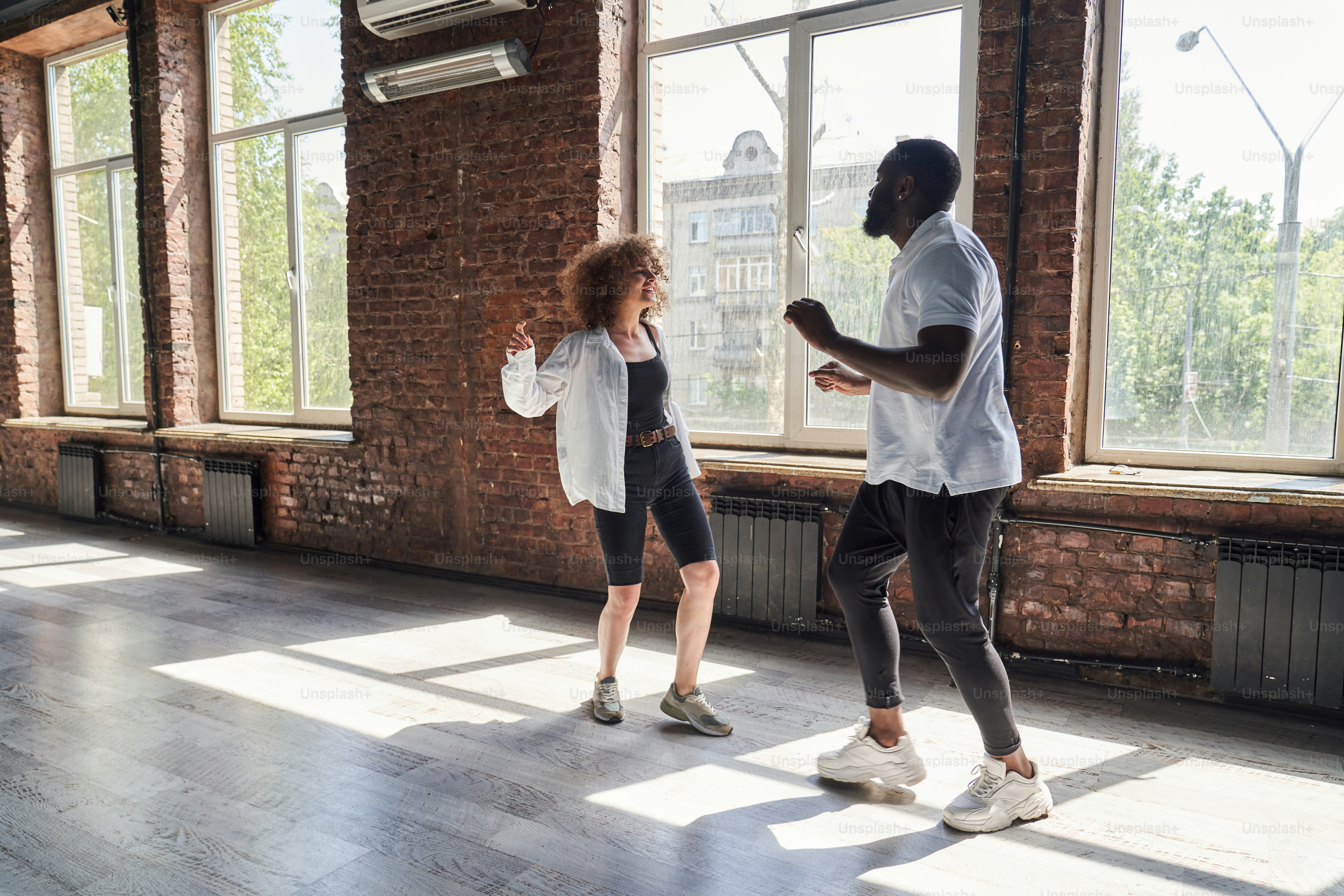 Two cheerful attractive people are leading active lifestyle and dancing ...