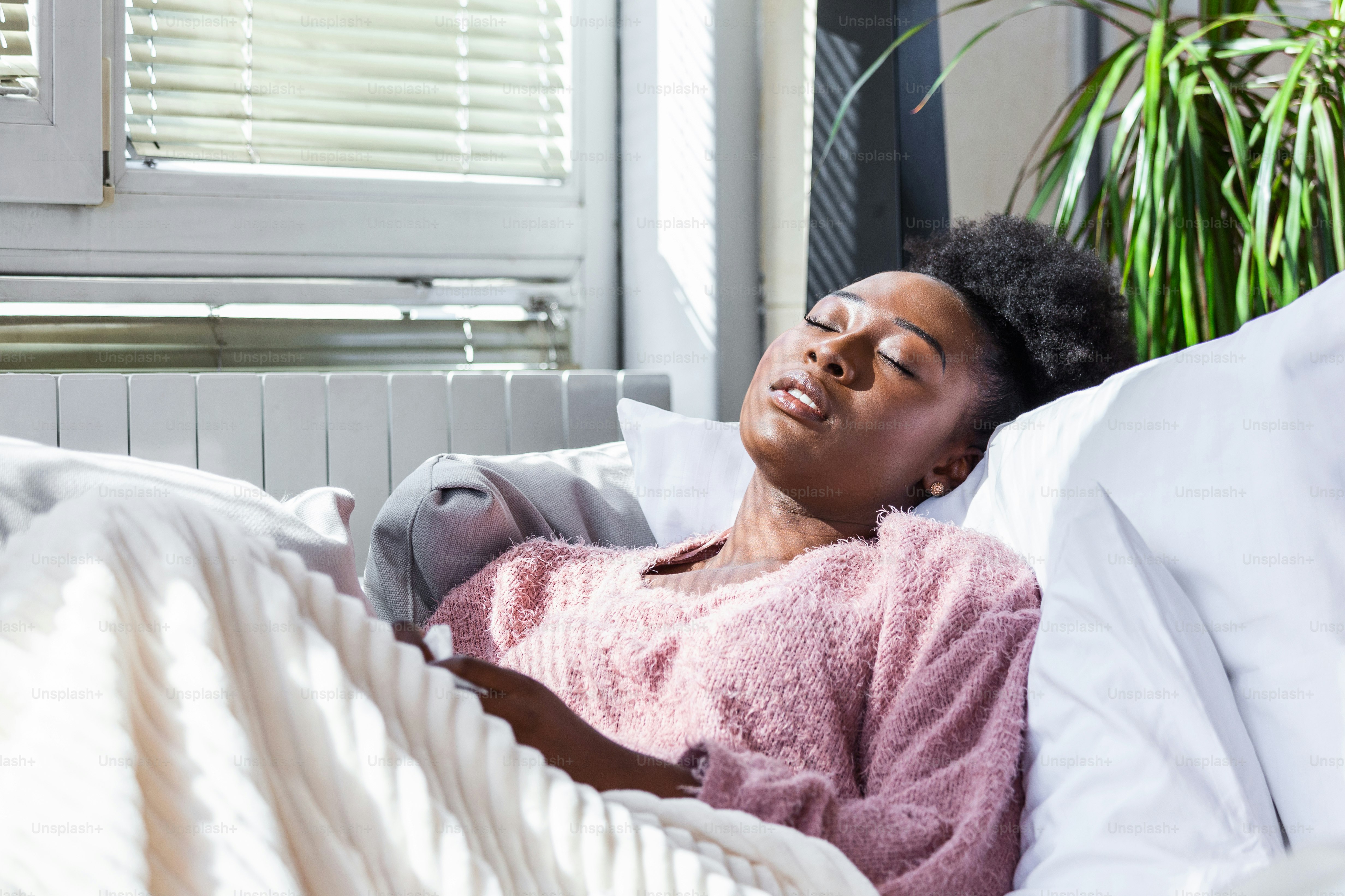 Sick young african woman feeling cold covered with blanket sit on bed ...