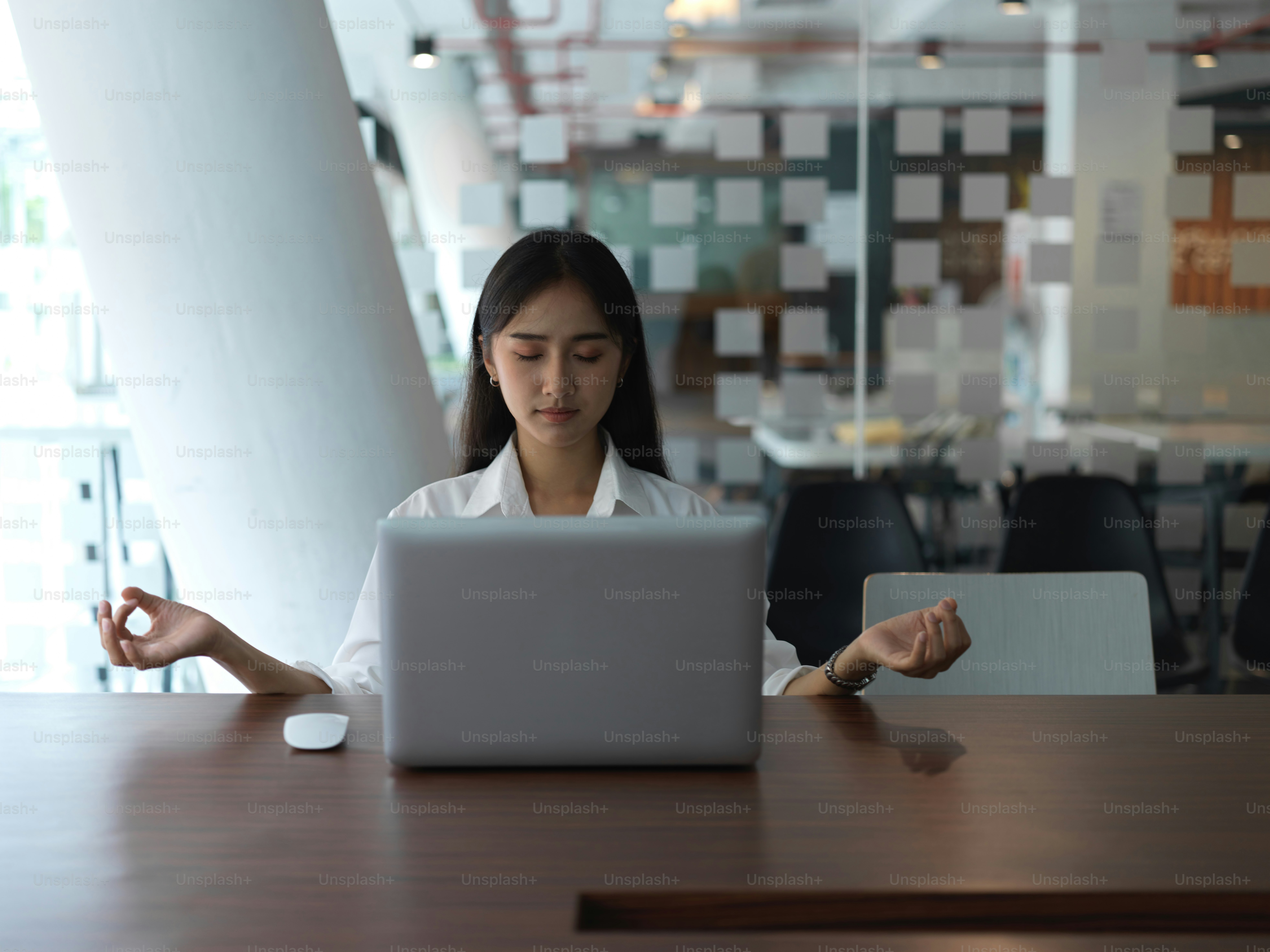 Portrait of female office worker meditating before start her ...