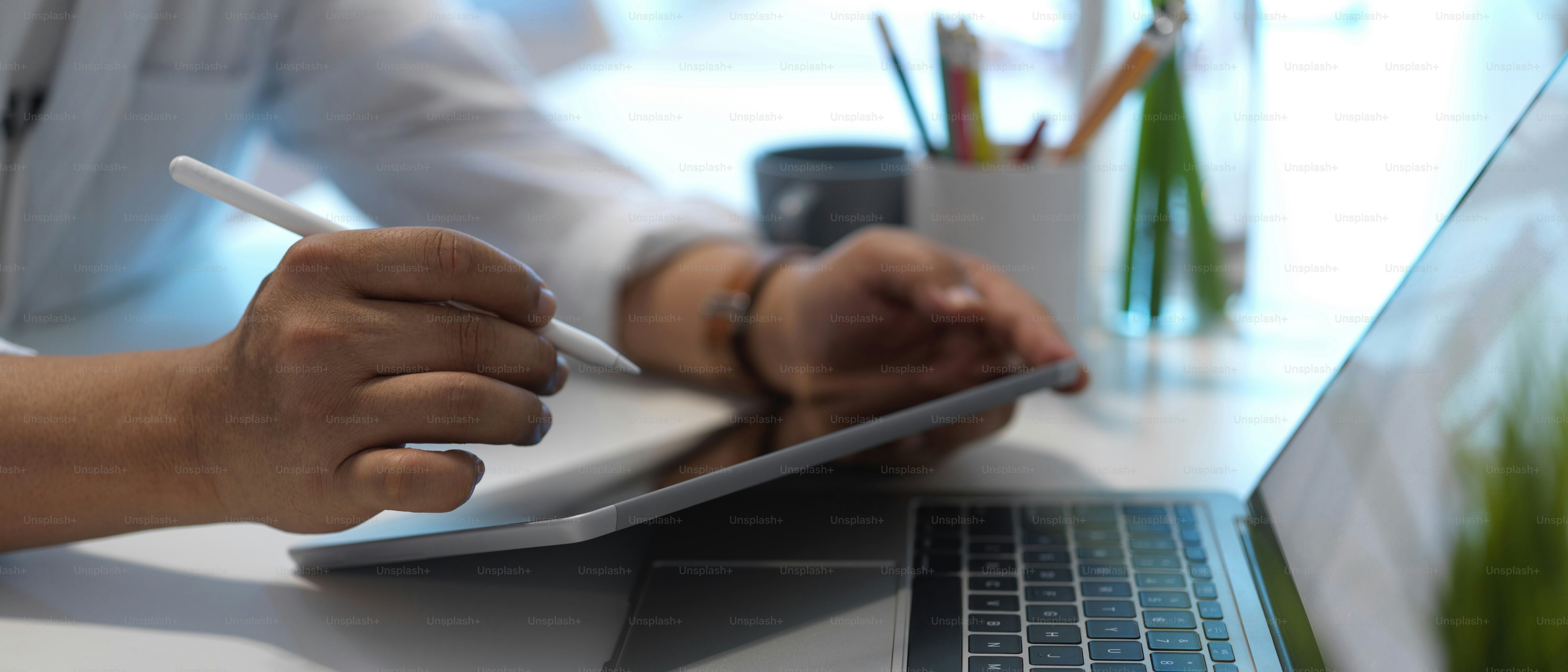 Close up view of male hand using digital tablet and holding coffee cup ...