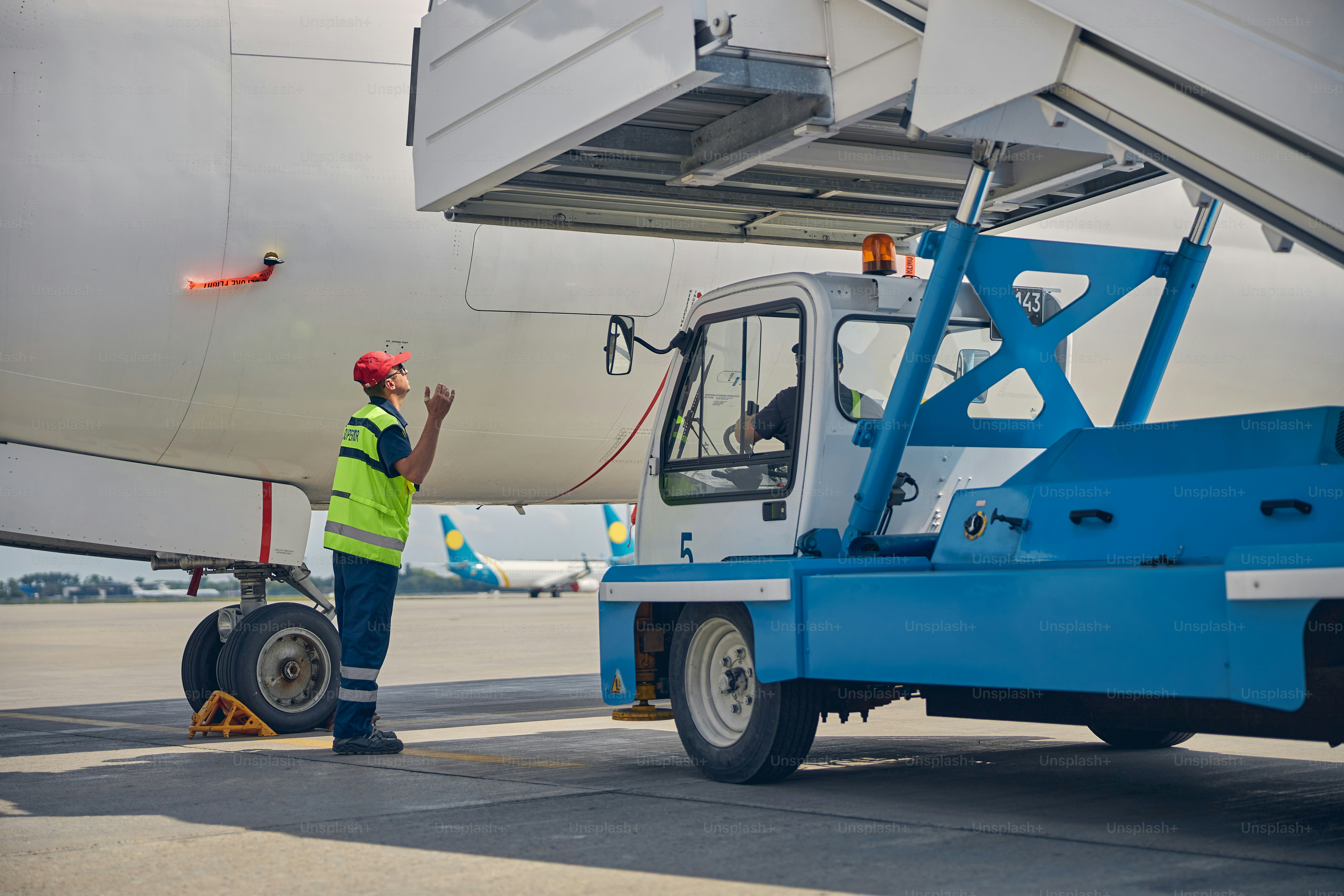 Skilled operator attaching the passenger boarding stairs to a civil ...