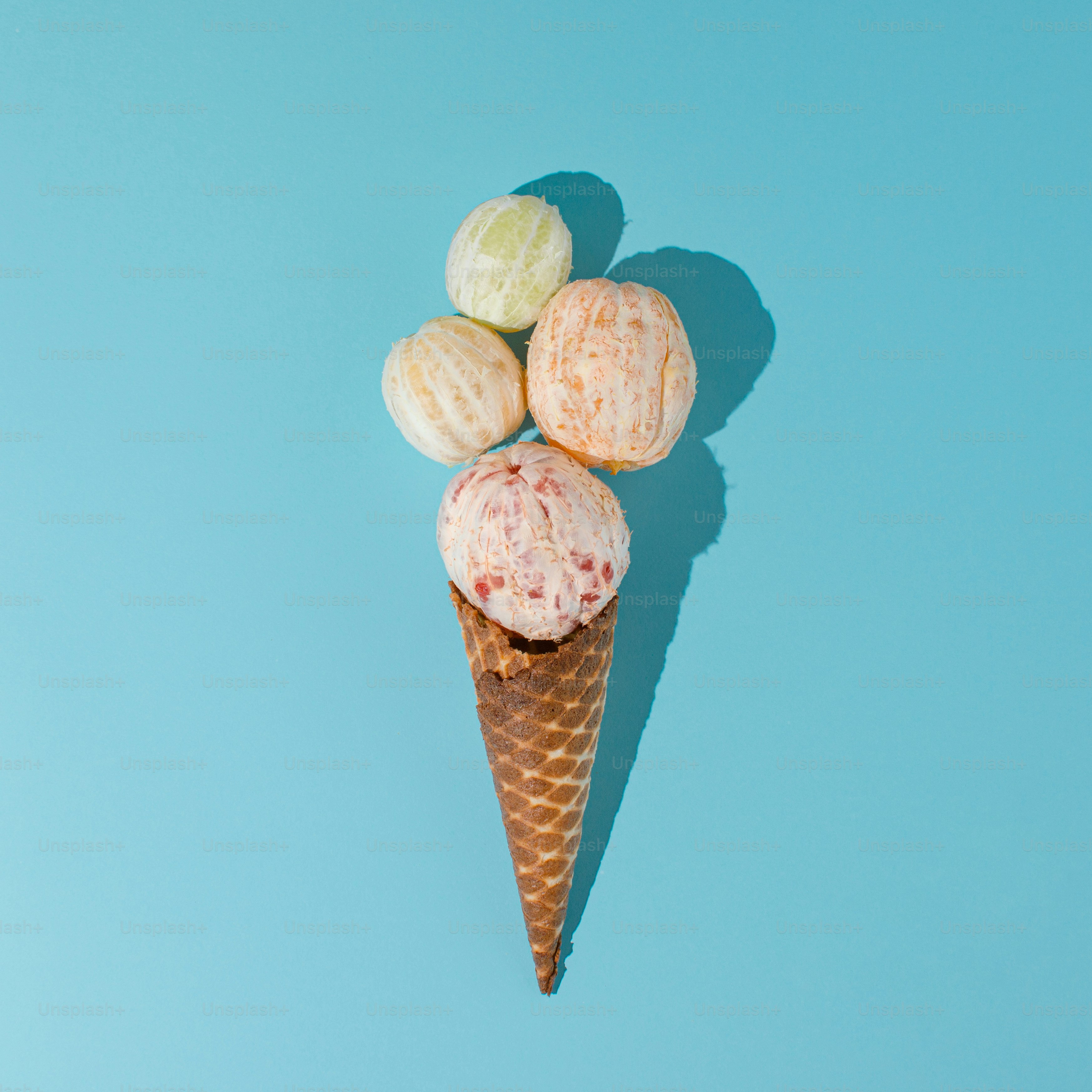 Ice cream cone with peeled citrus fruits on cyan background. Minimal ...