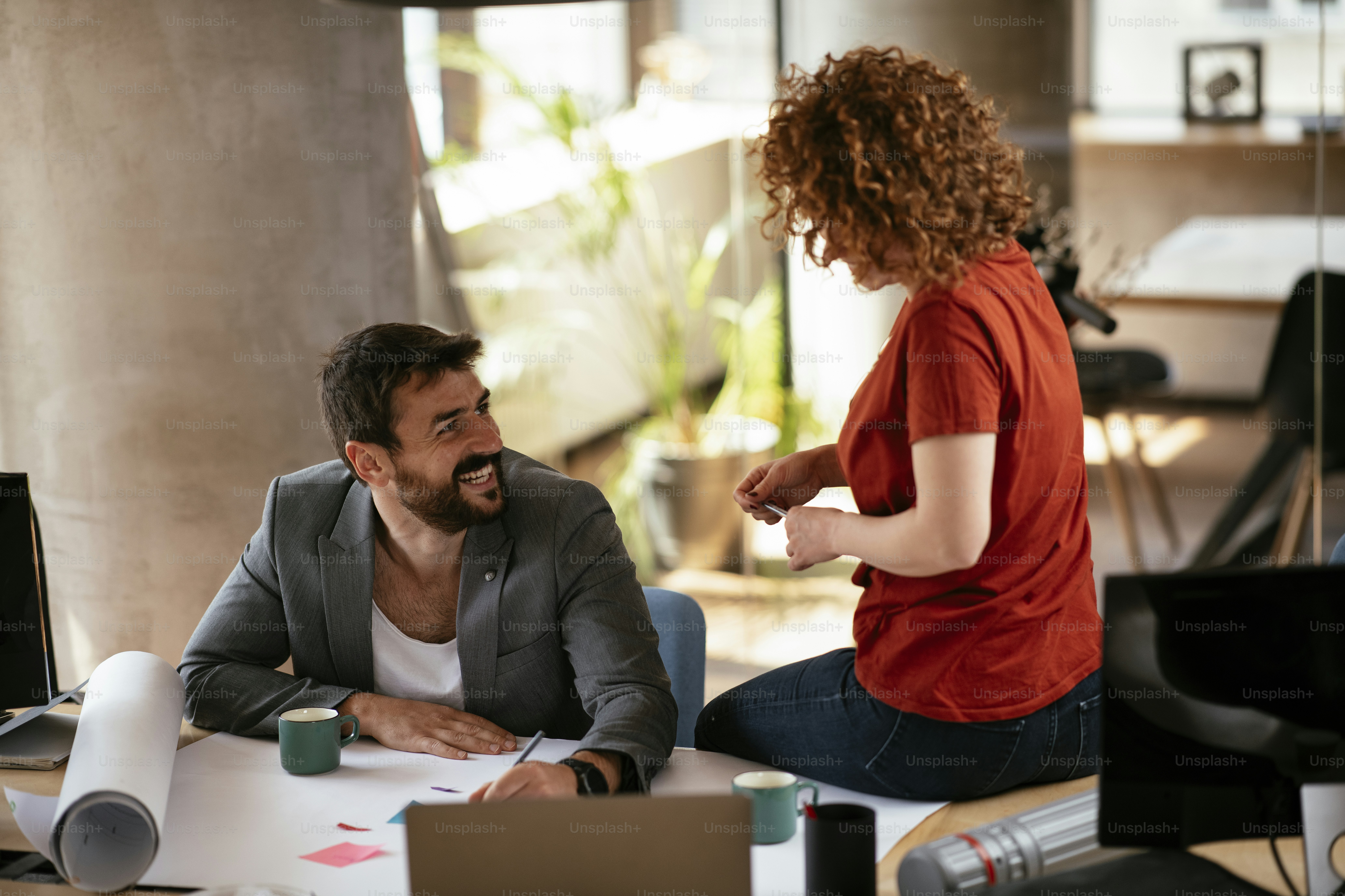 Businessman and businesswoman talking in office. Two friends working on ...